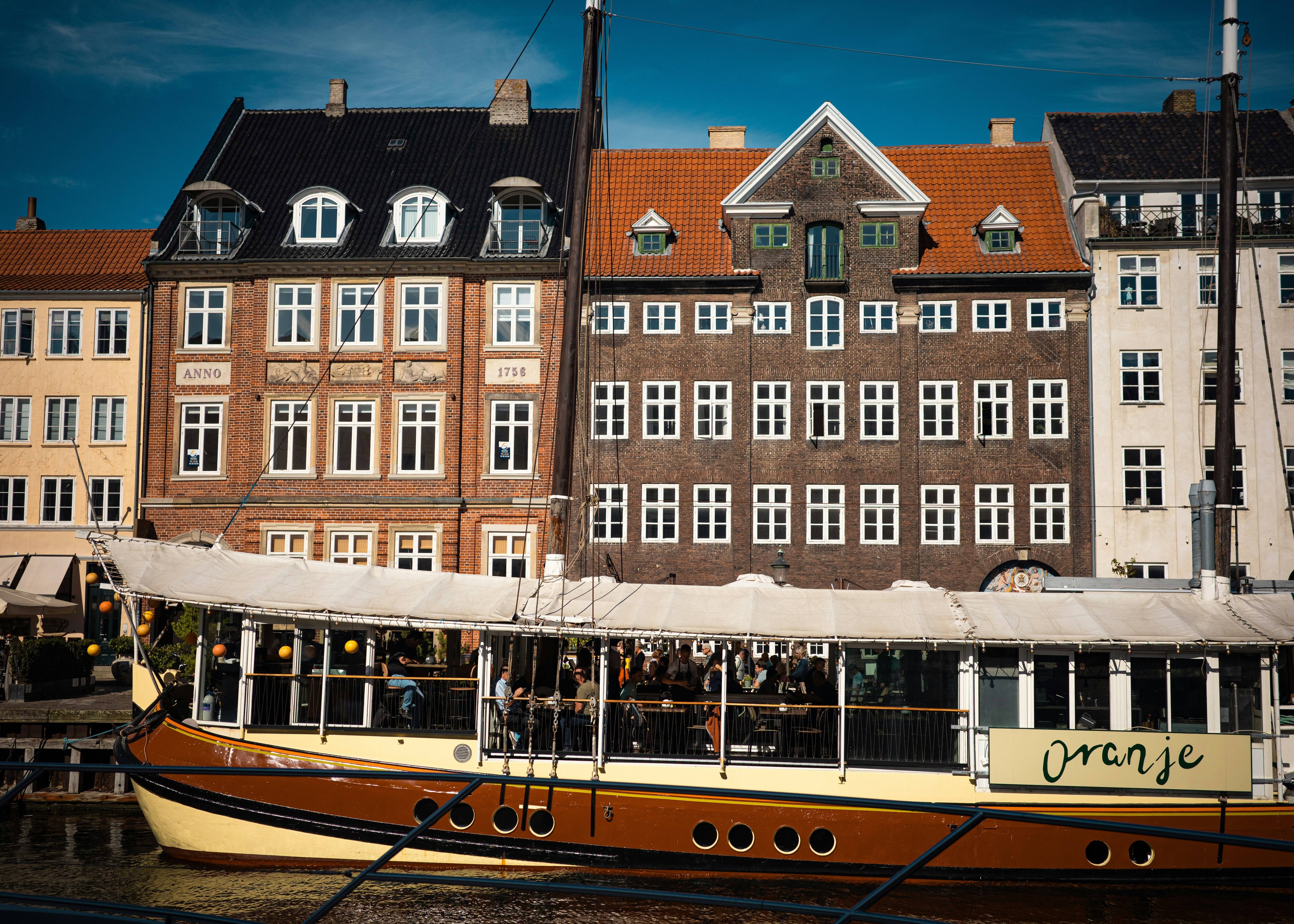 Riverside Dannebrog: Boatside Café beside a Row of Colorful Townhouses