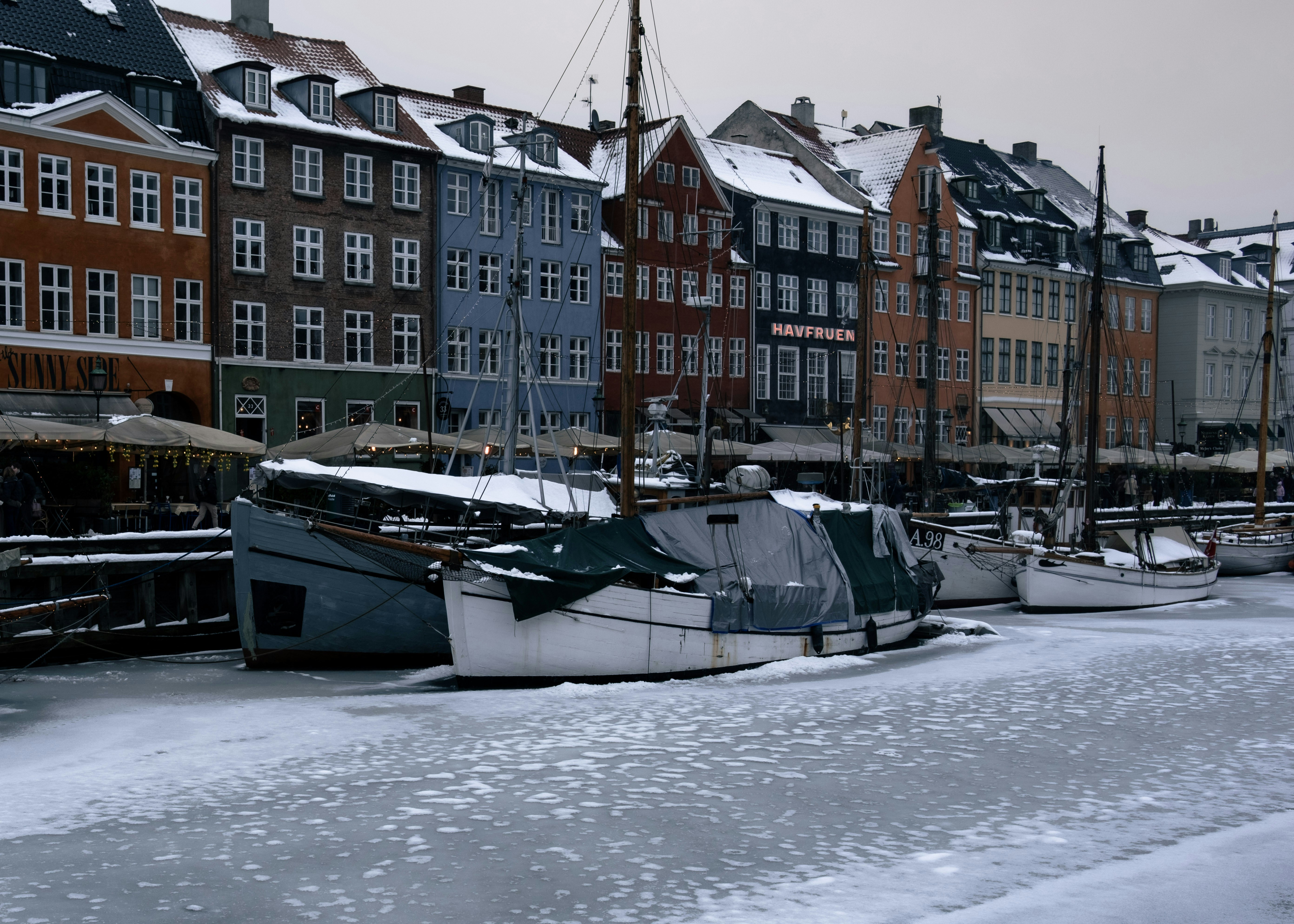 Snow-coated harbor wakes with pastel row houses