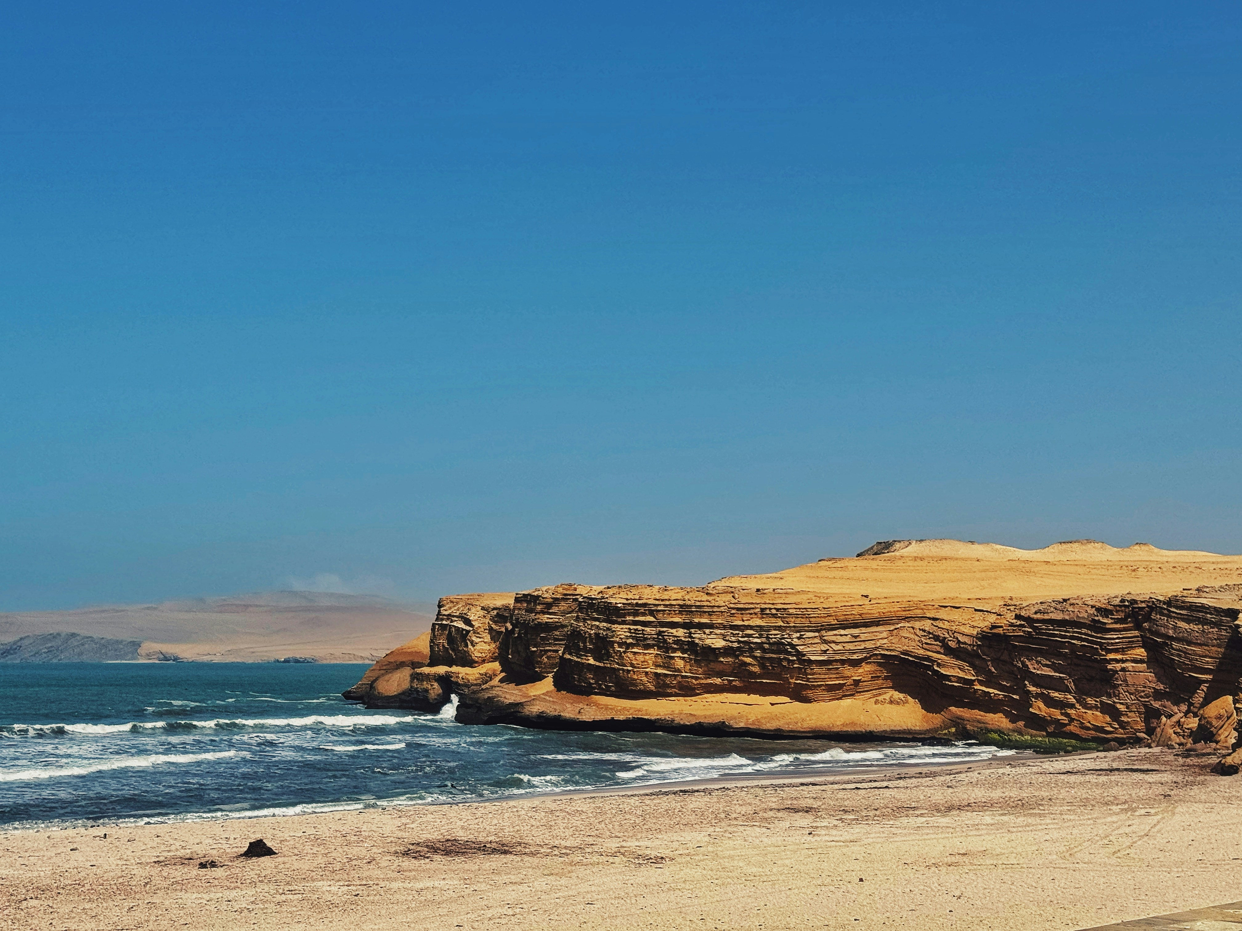 Sunlit Cliffs and Quiet Sea: A Coastal Vista