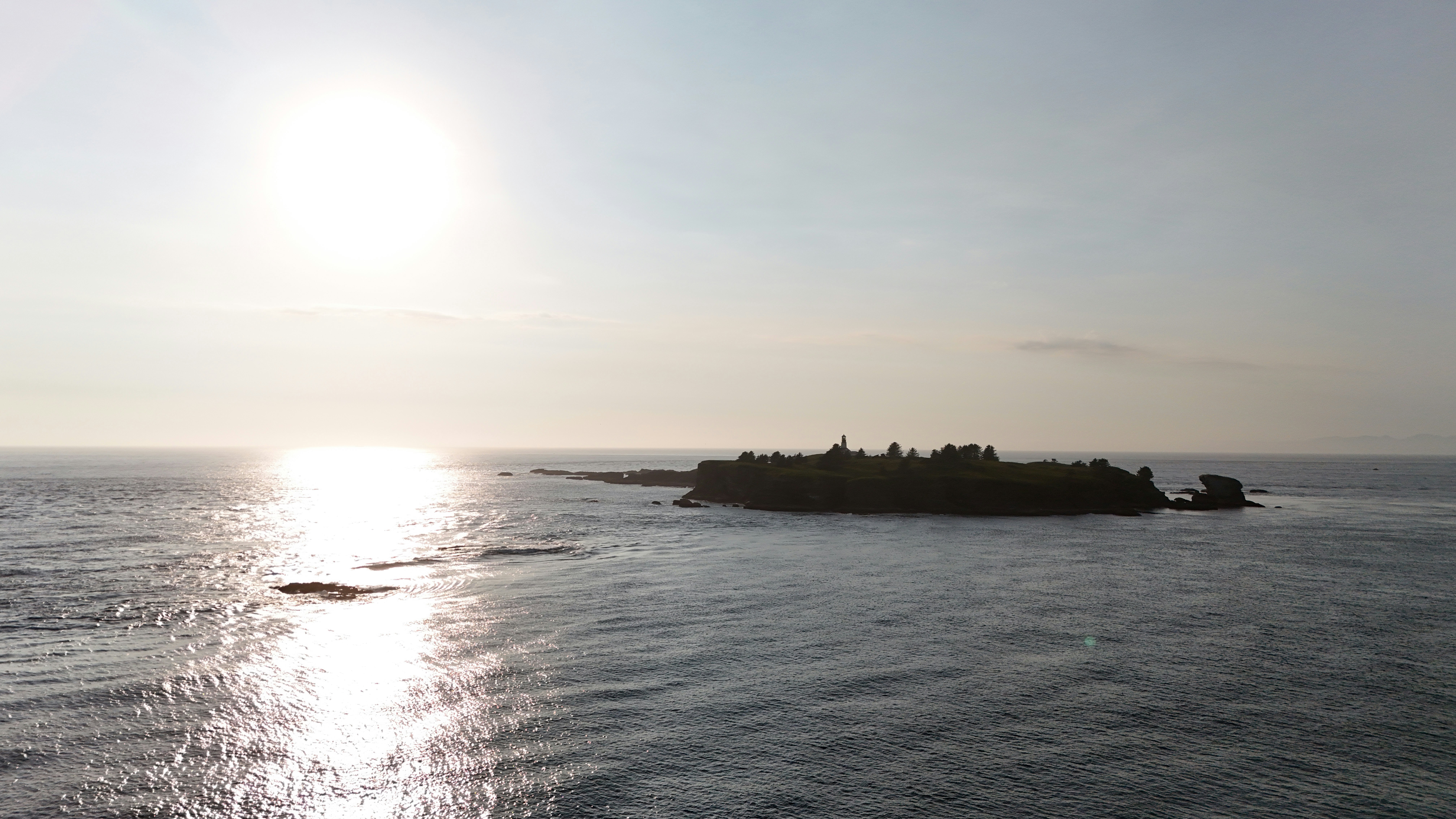 Sunlit Island Silhouette Over a Calm Sea