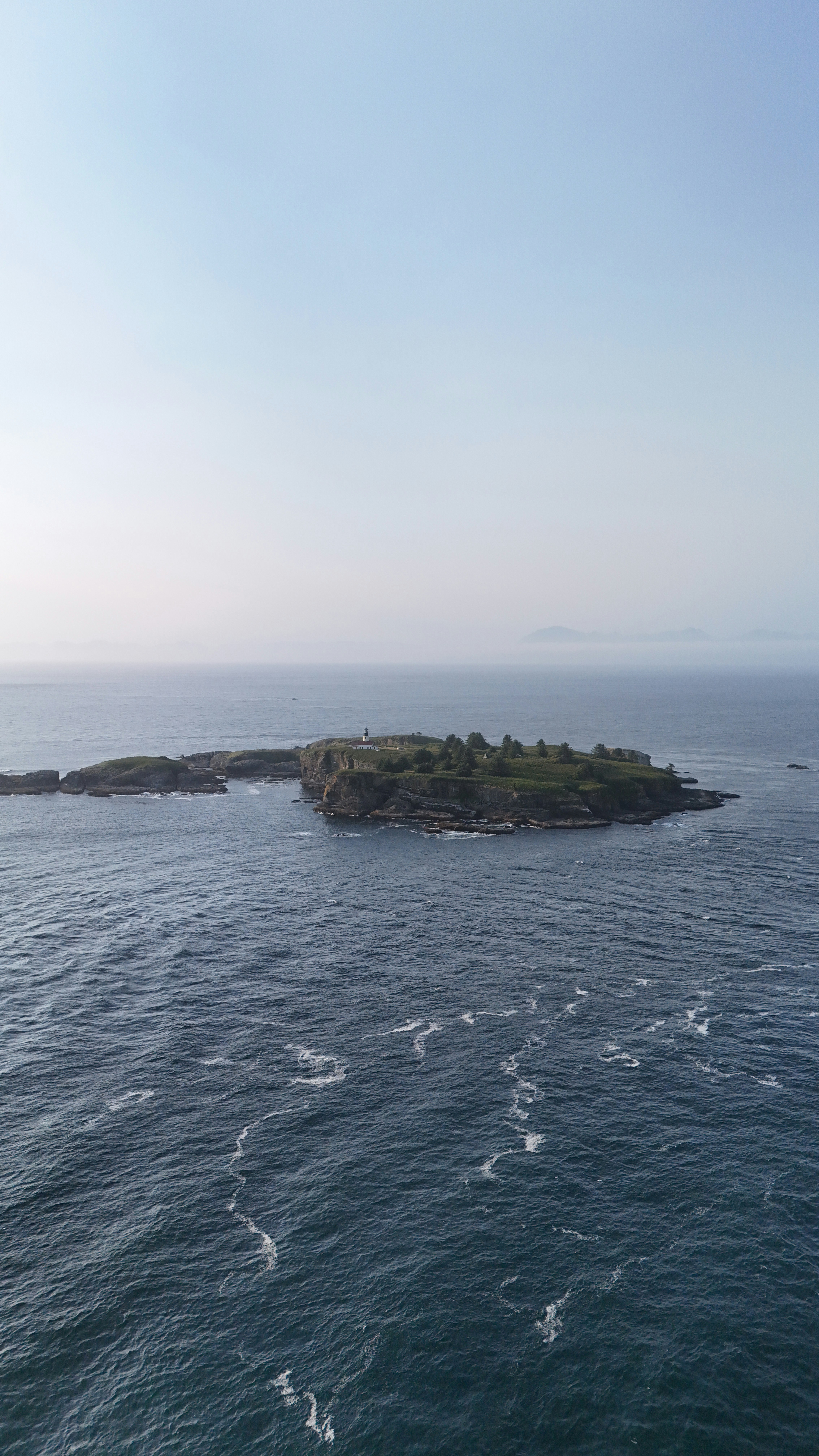 Isolated outpost: rocky islet meeting the open sea at dawn