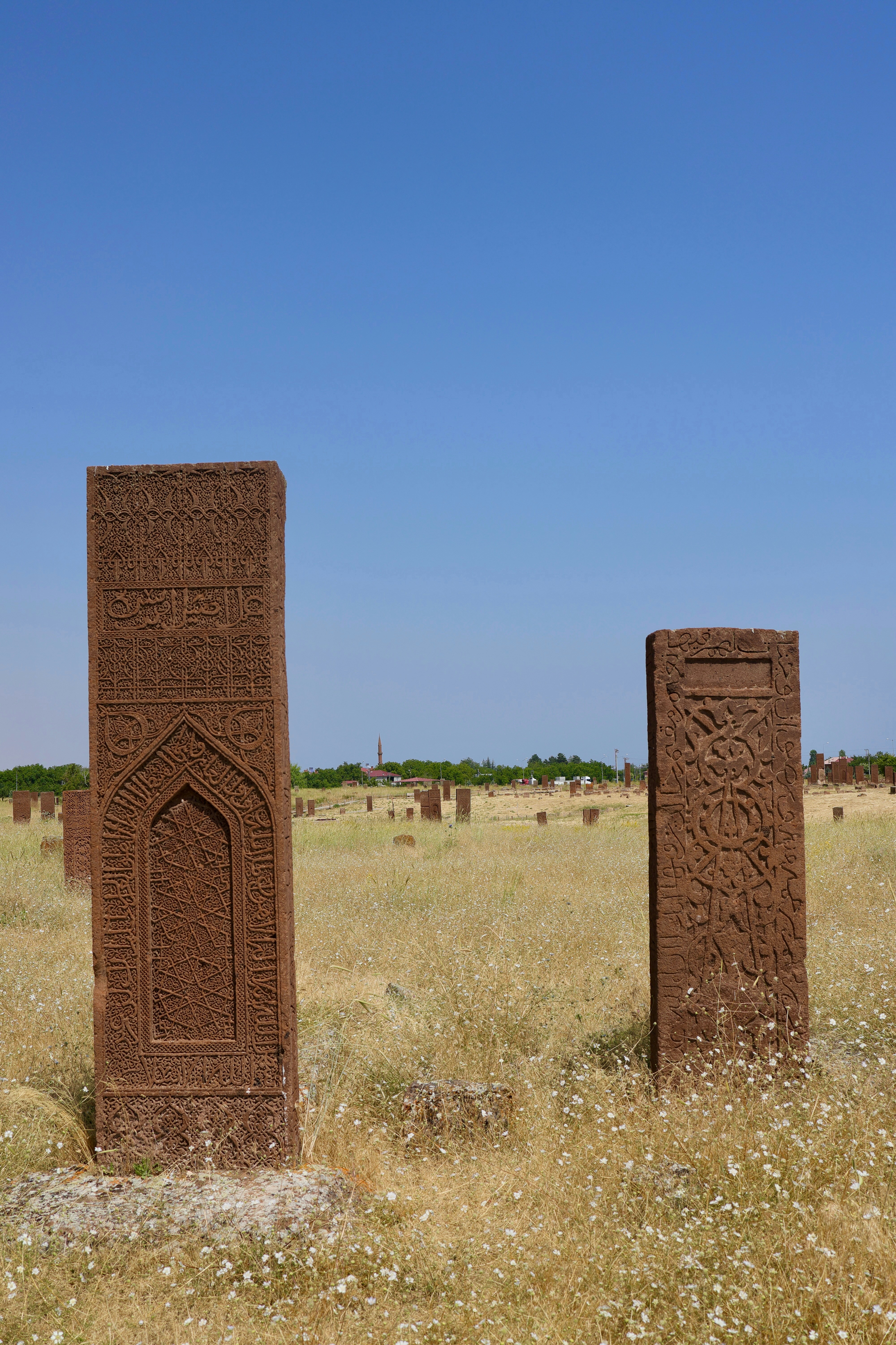 Two Ancient Obelisks Rise in a Sunlit Steppe Cemetery