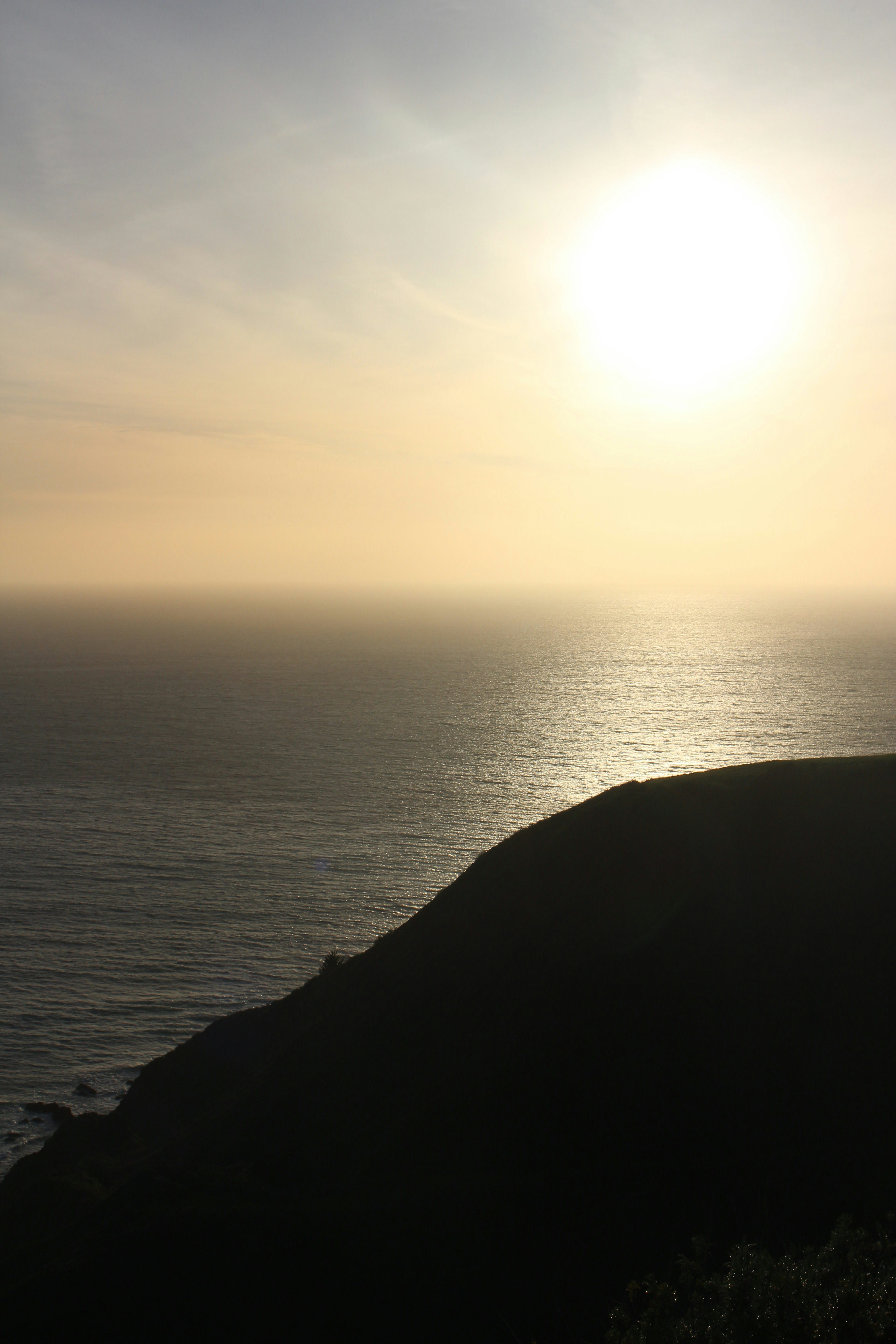 Sunlit Cliff Over Ocean: A Quiet Dusk Over the Horizon