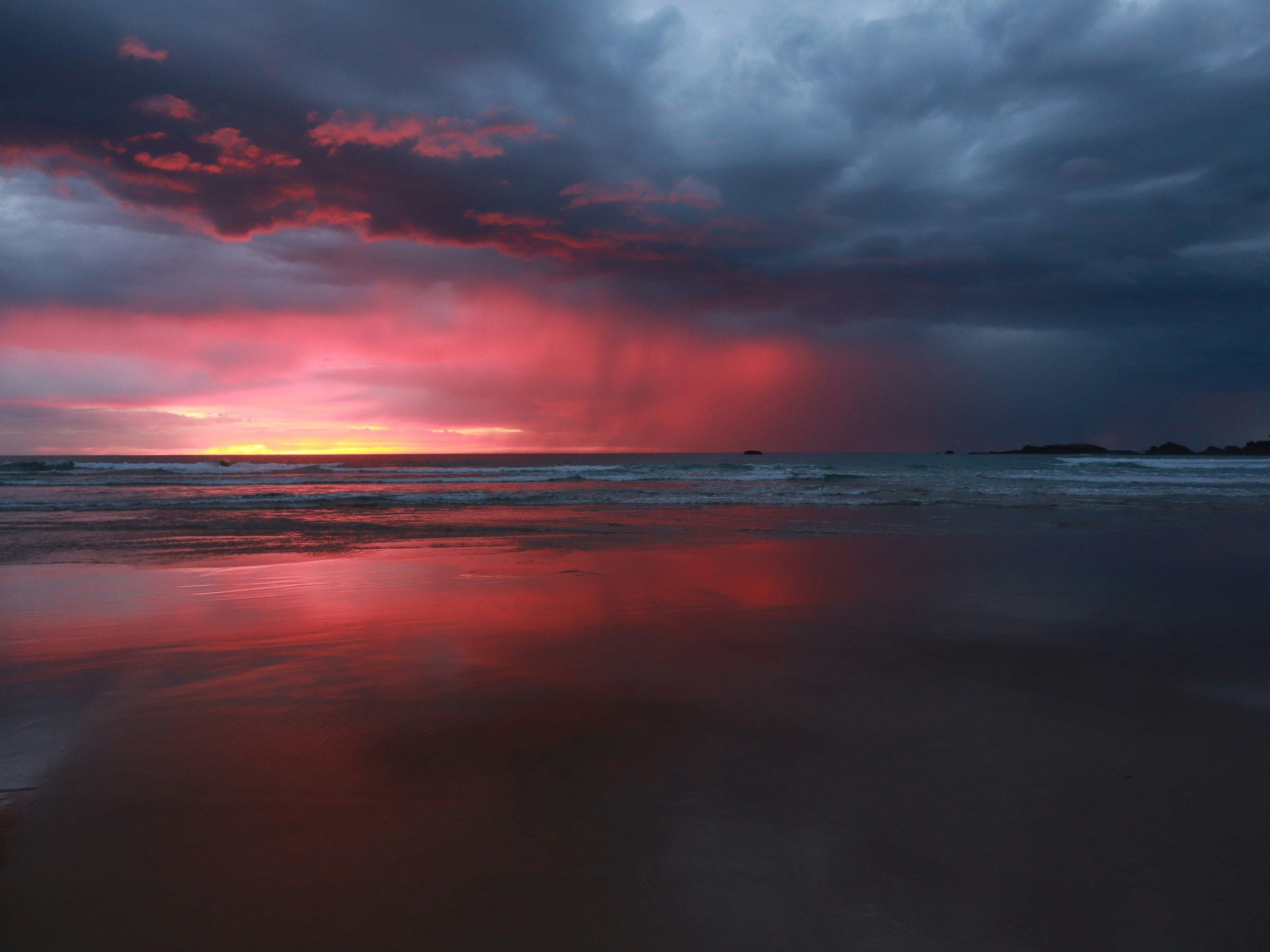 Crimson Horizon: Storm-turned Sunset Over a Quiet Shore