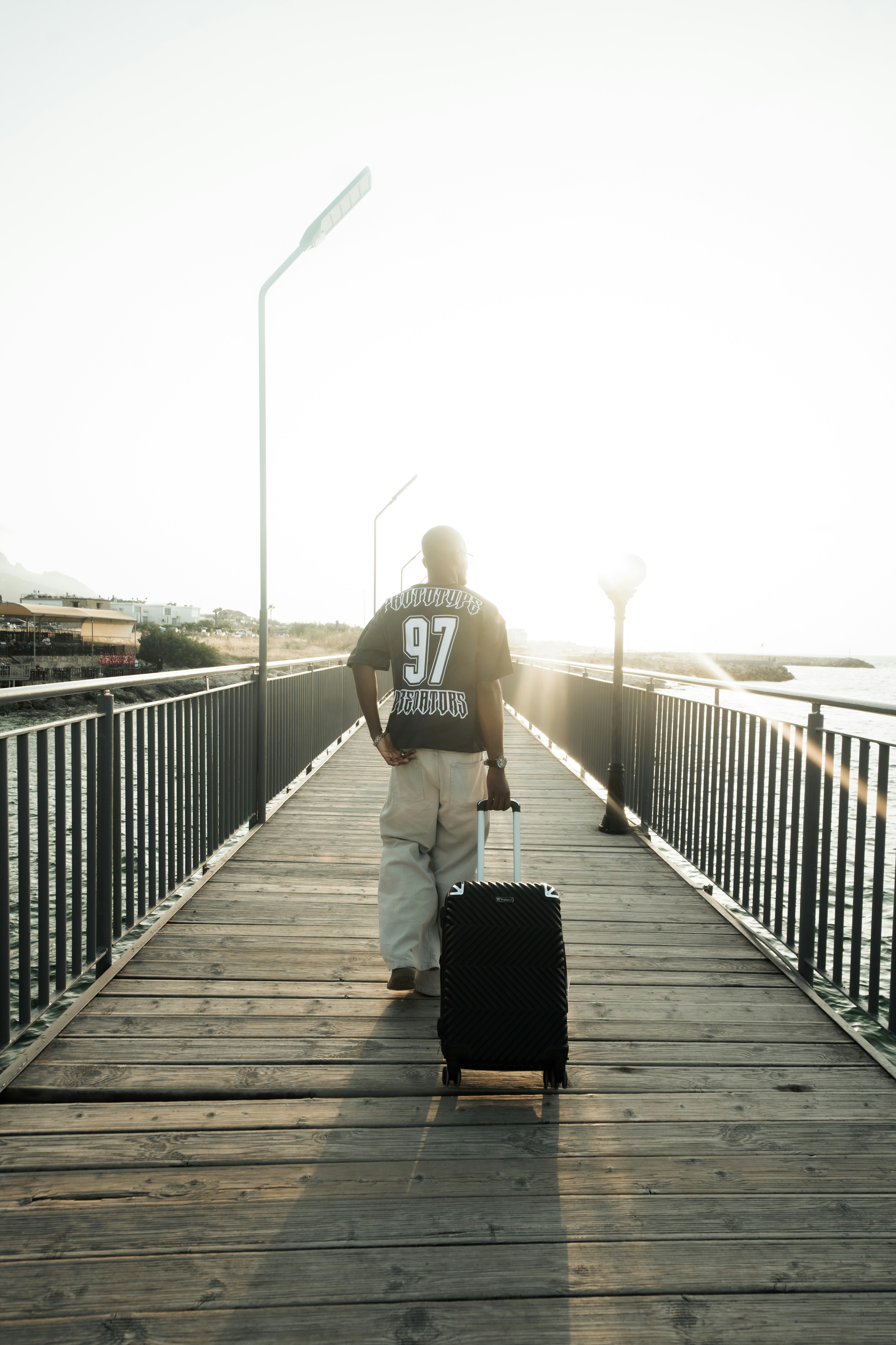 Traveler on the Sunlit Pier: Journey with a Luggage in Tow