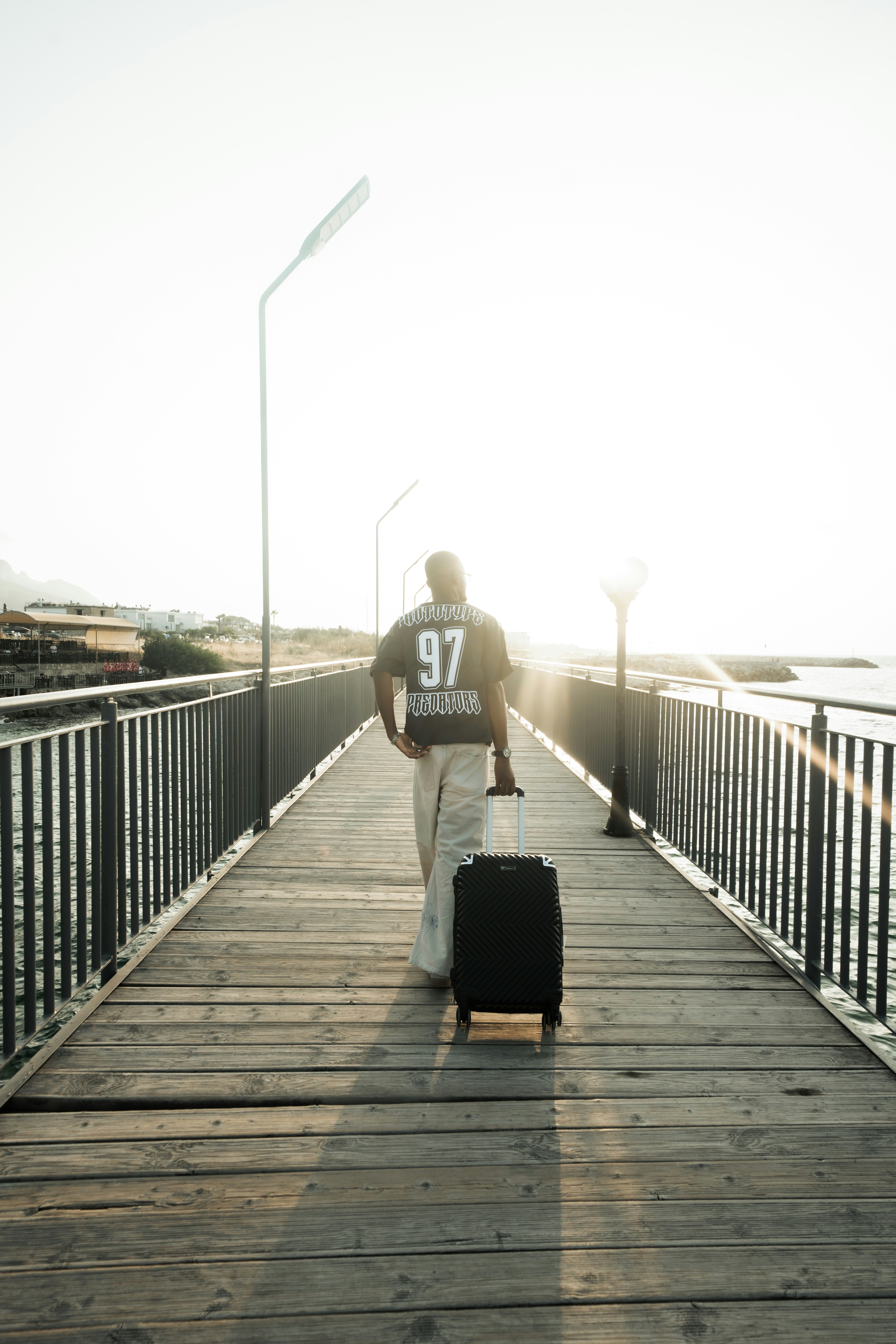 Traveler with a Luggage on a Sunlit Boardwalk