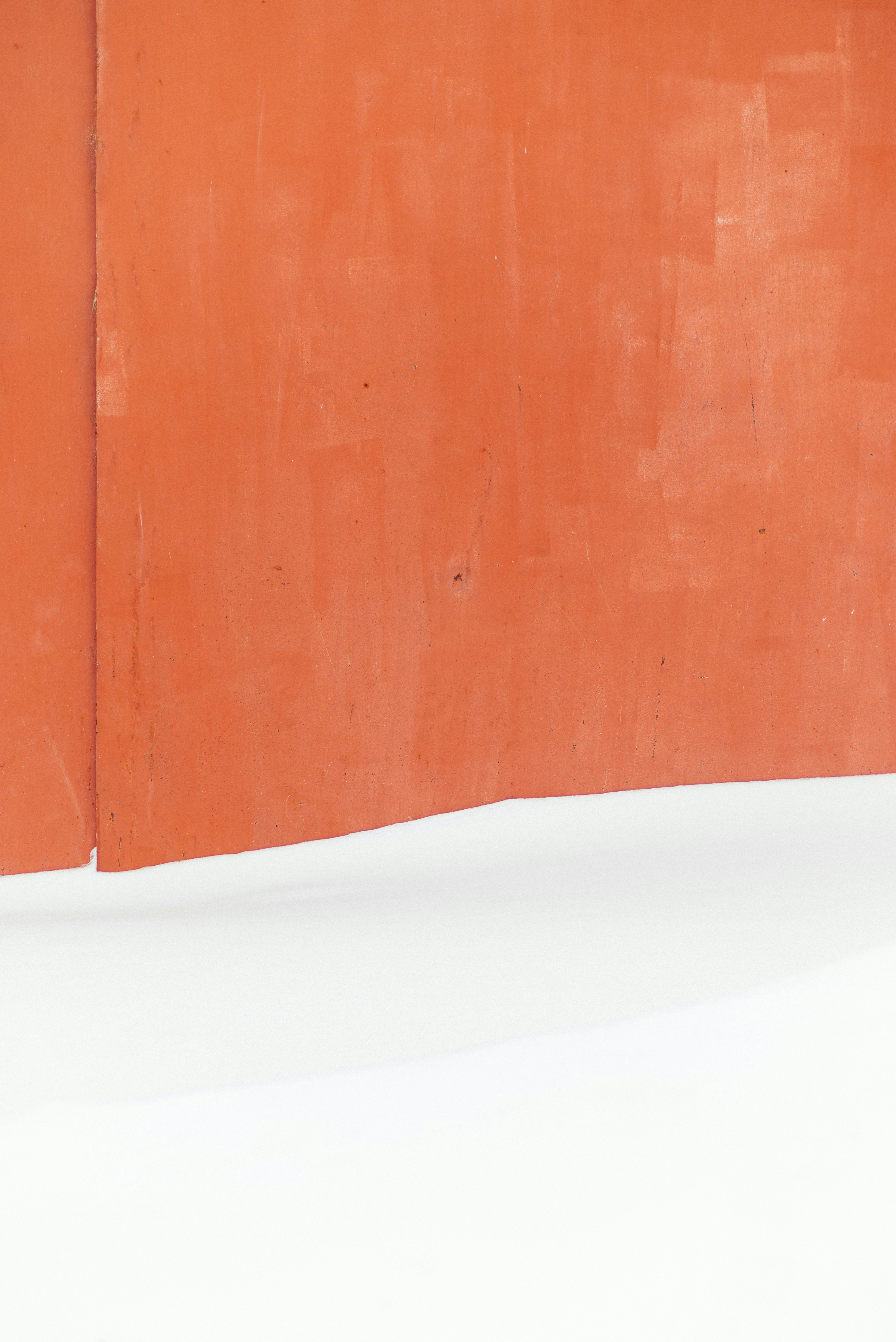 Orange Wood Panel Against Snow Cover with Soft Shadow Line