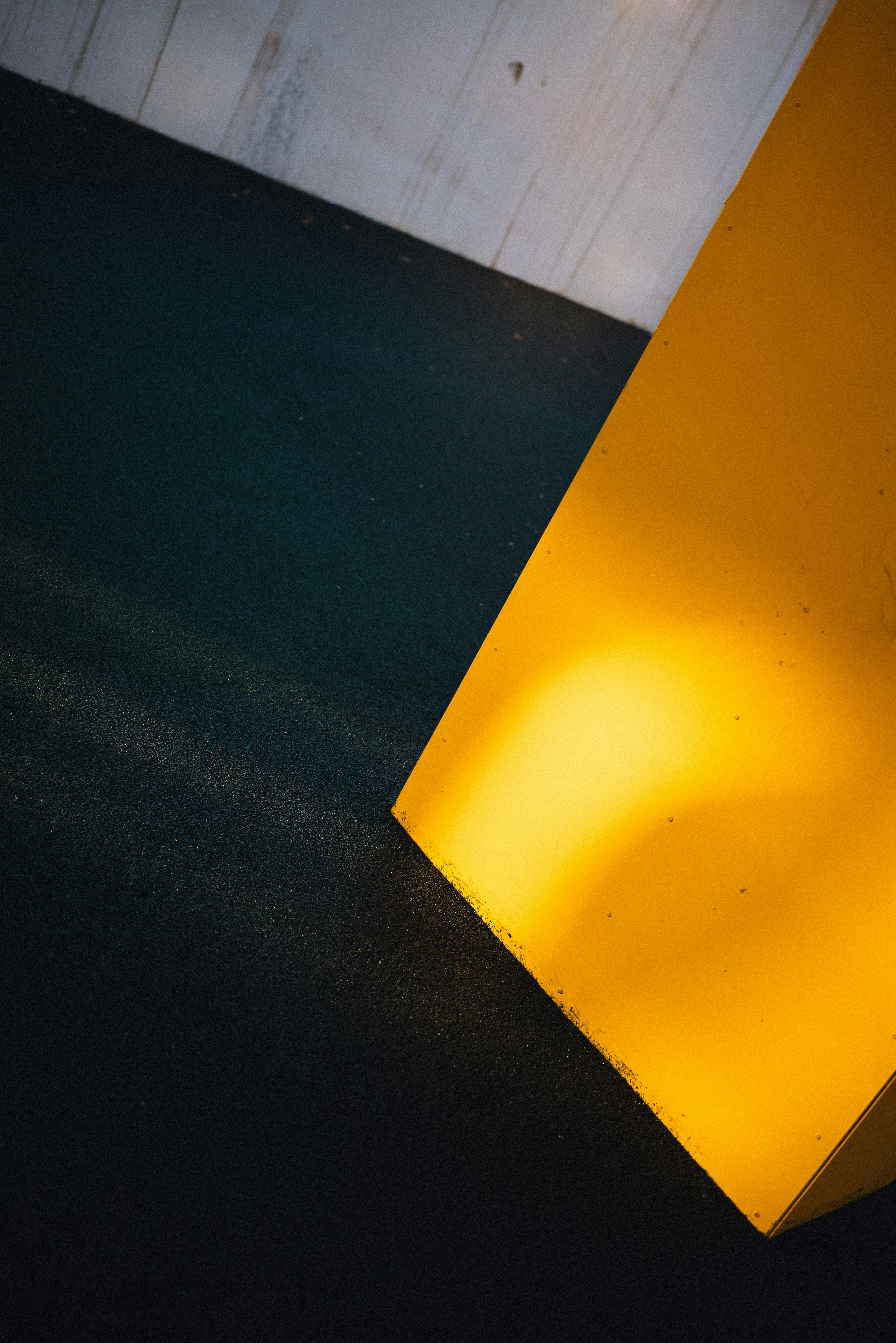 Angles of Light: A Bold Yellow Corner Meets Dark Asphalt