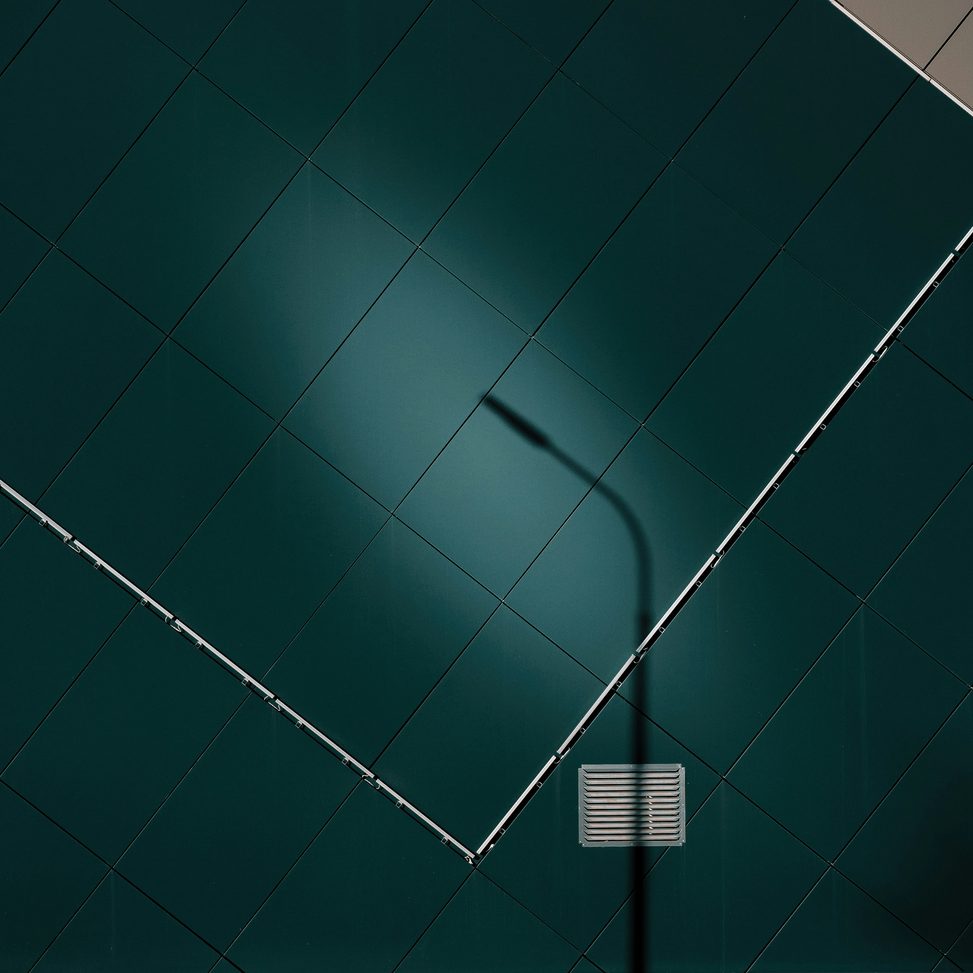 Geometric teal tones meet a curved streetlamp silhouette