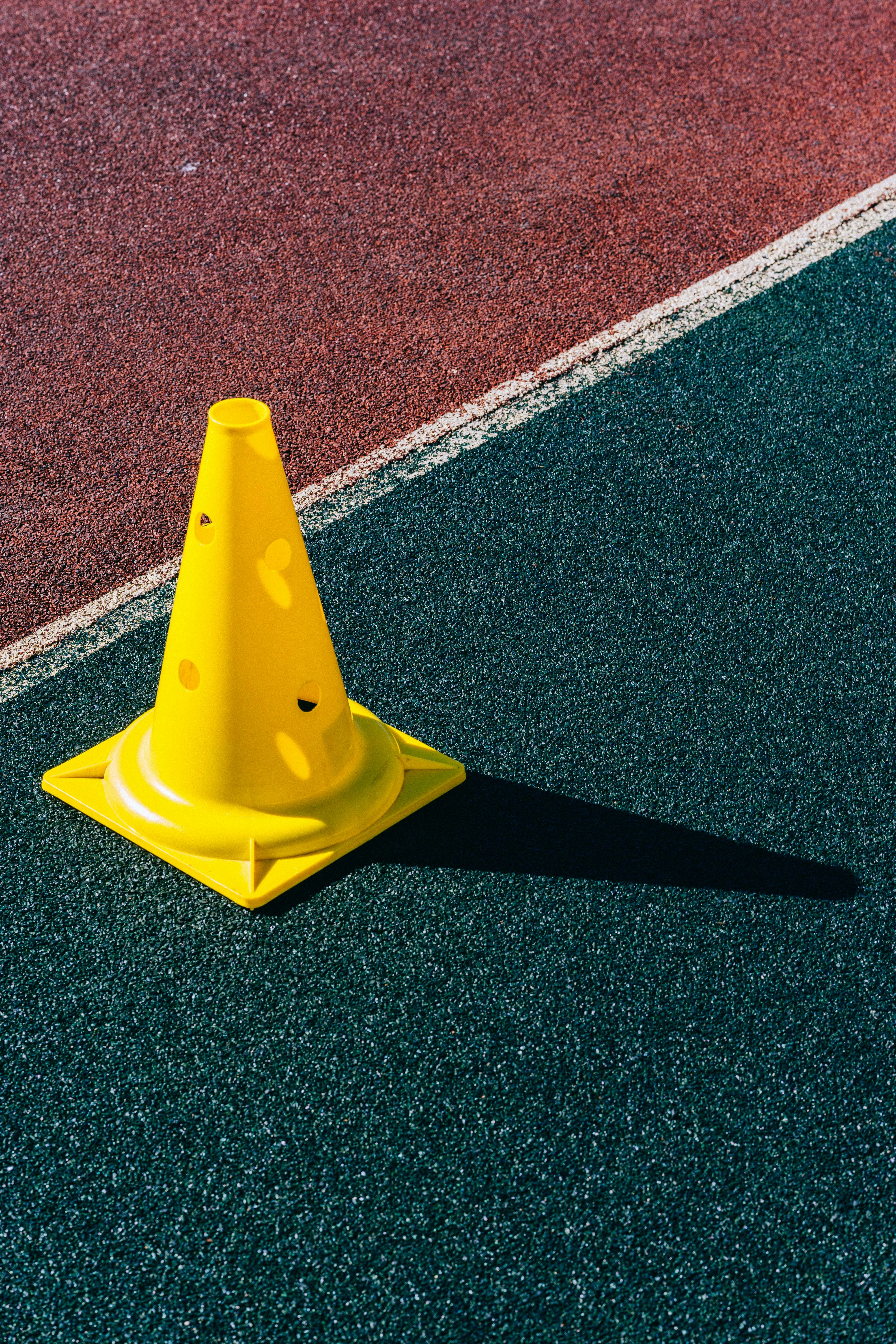 Yellow Cone on a Dual-Tone Court Cast in Long Shadow