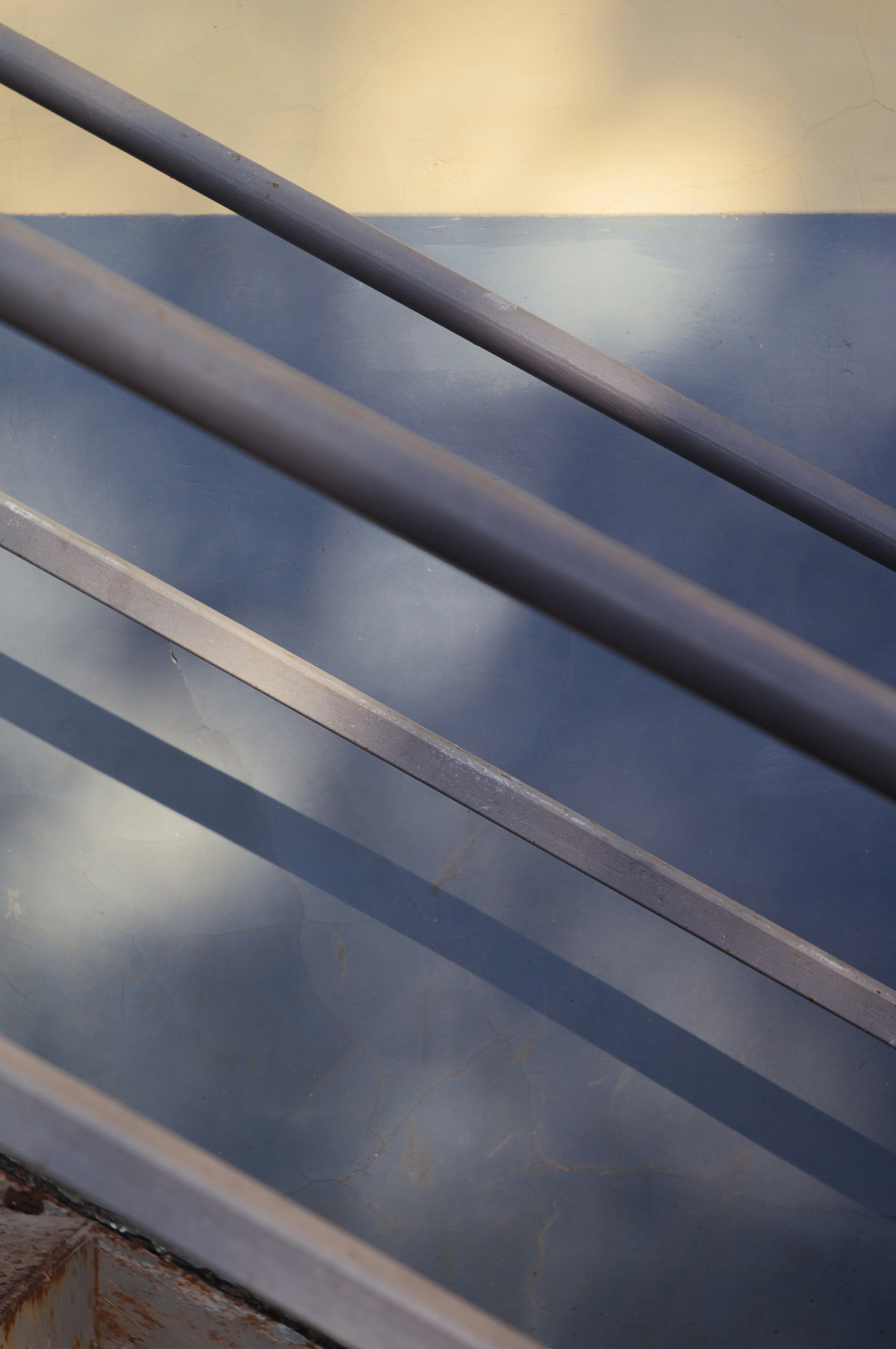 Lines in Shadow: Parallel Rails Across Glass and Steel