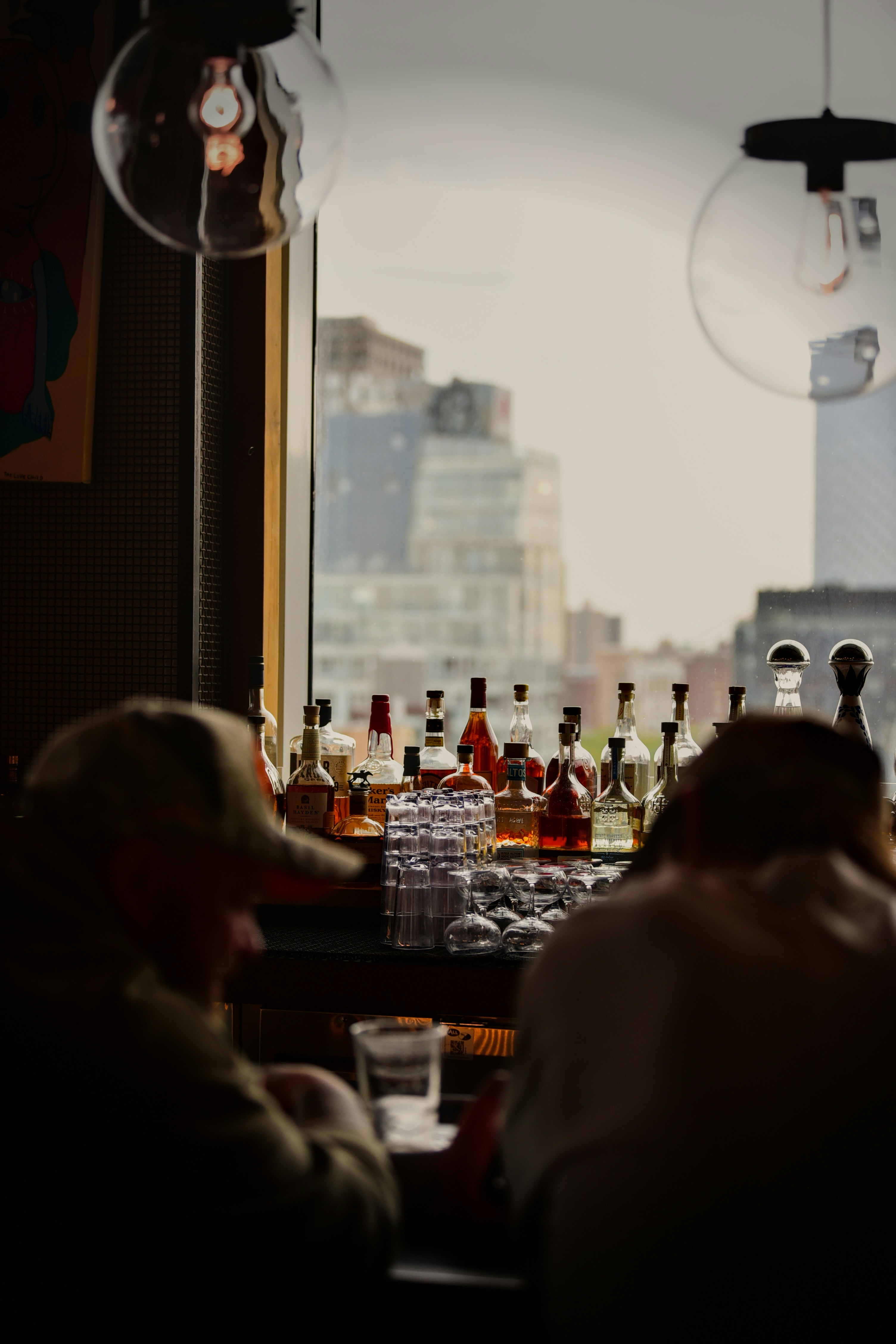 City Bar at Dusk: Bottles, Lightbulbs, and Evening Silhouettes