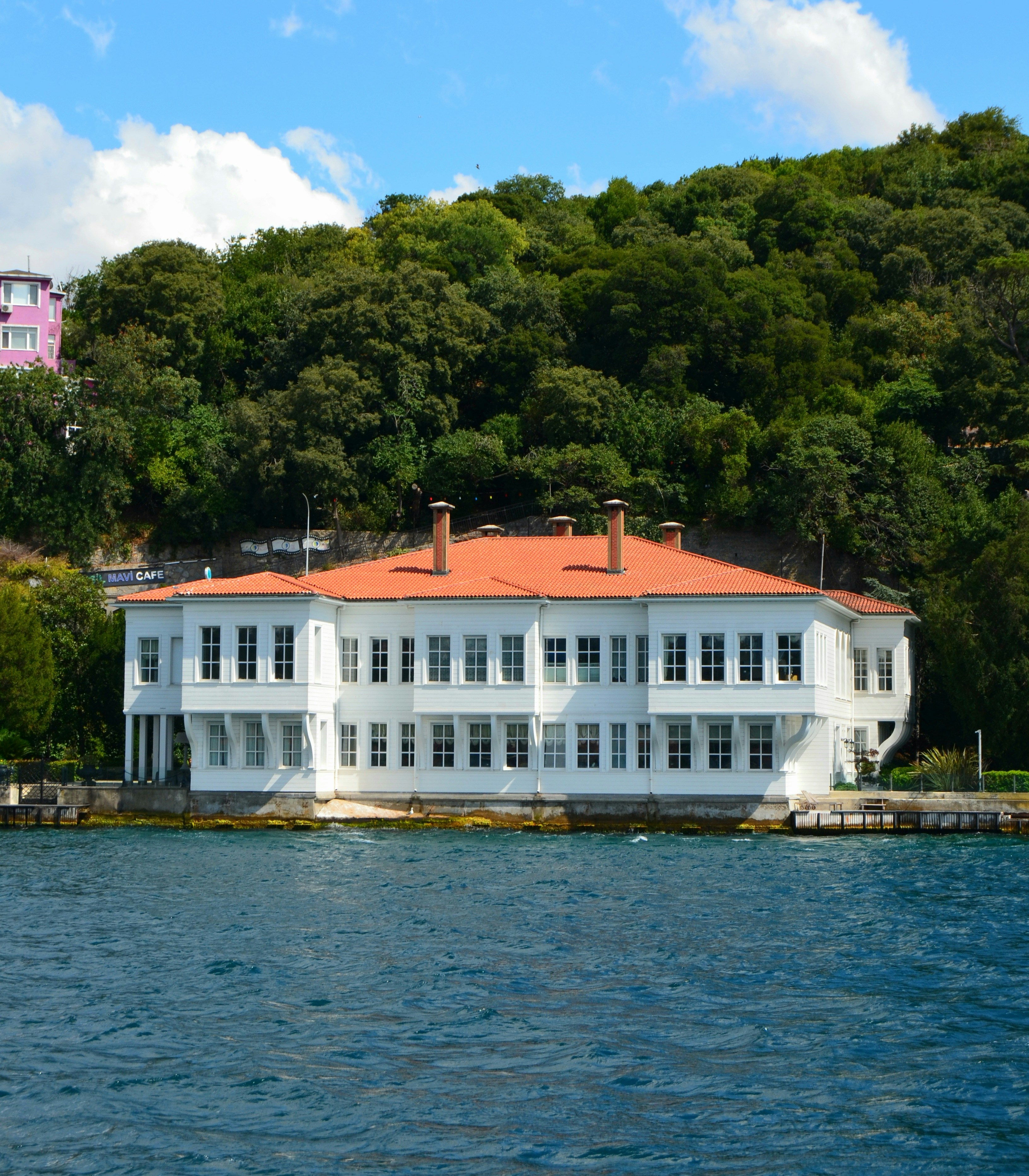 White riverside manor afloat on calm blue waters