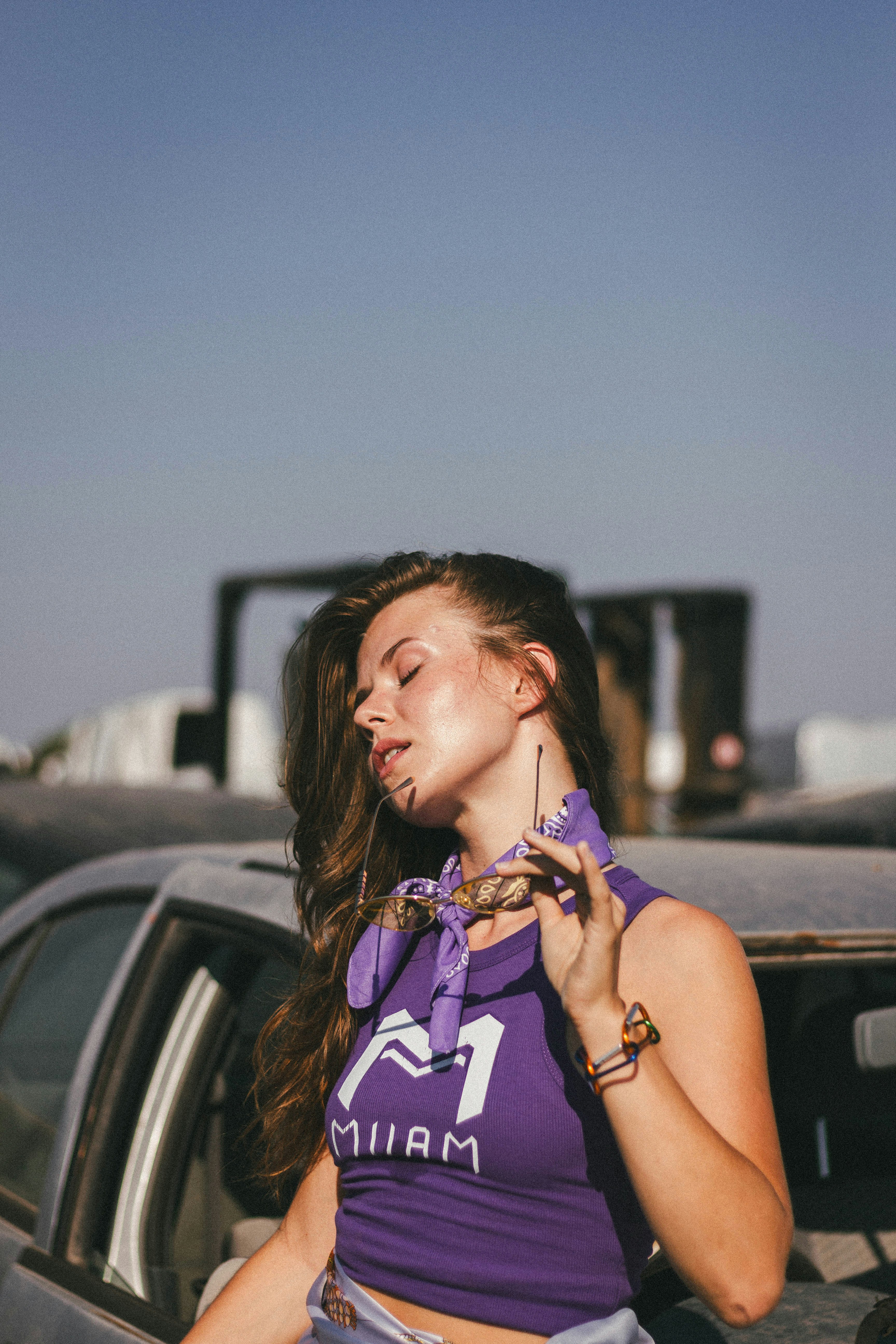 Purple-Tinted Confidence: A Sunlit Portrait by the Car Rails