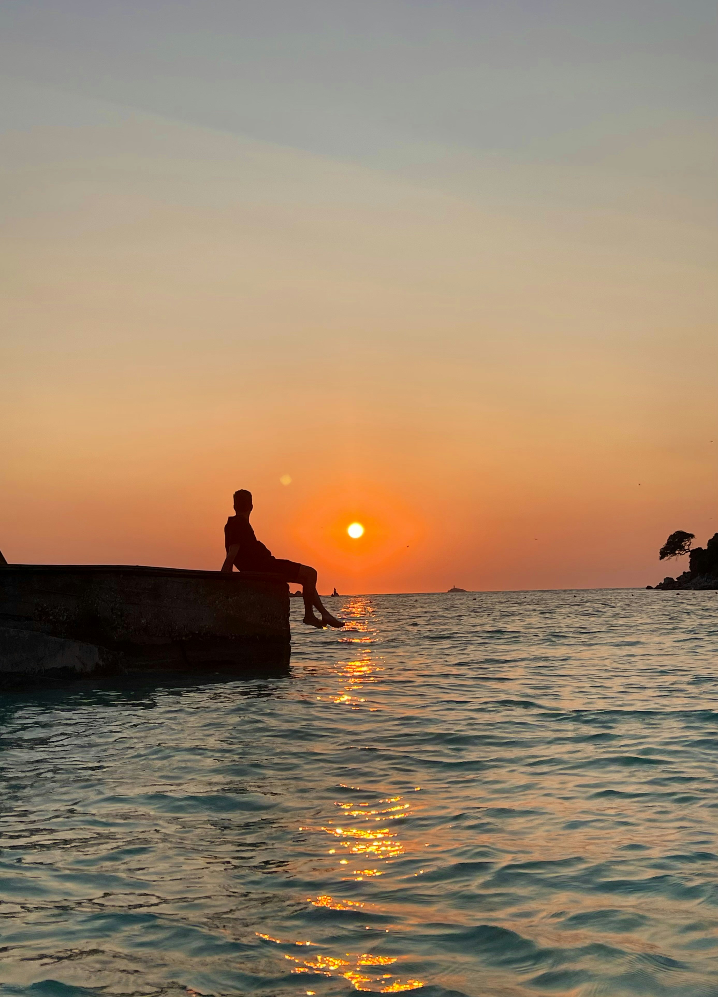 Sunset Solitude: A Silhouetted Figure at the Pier's Edge