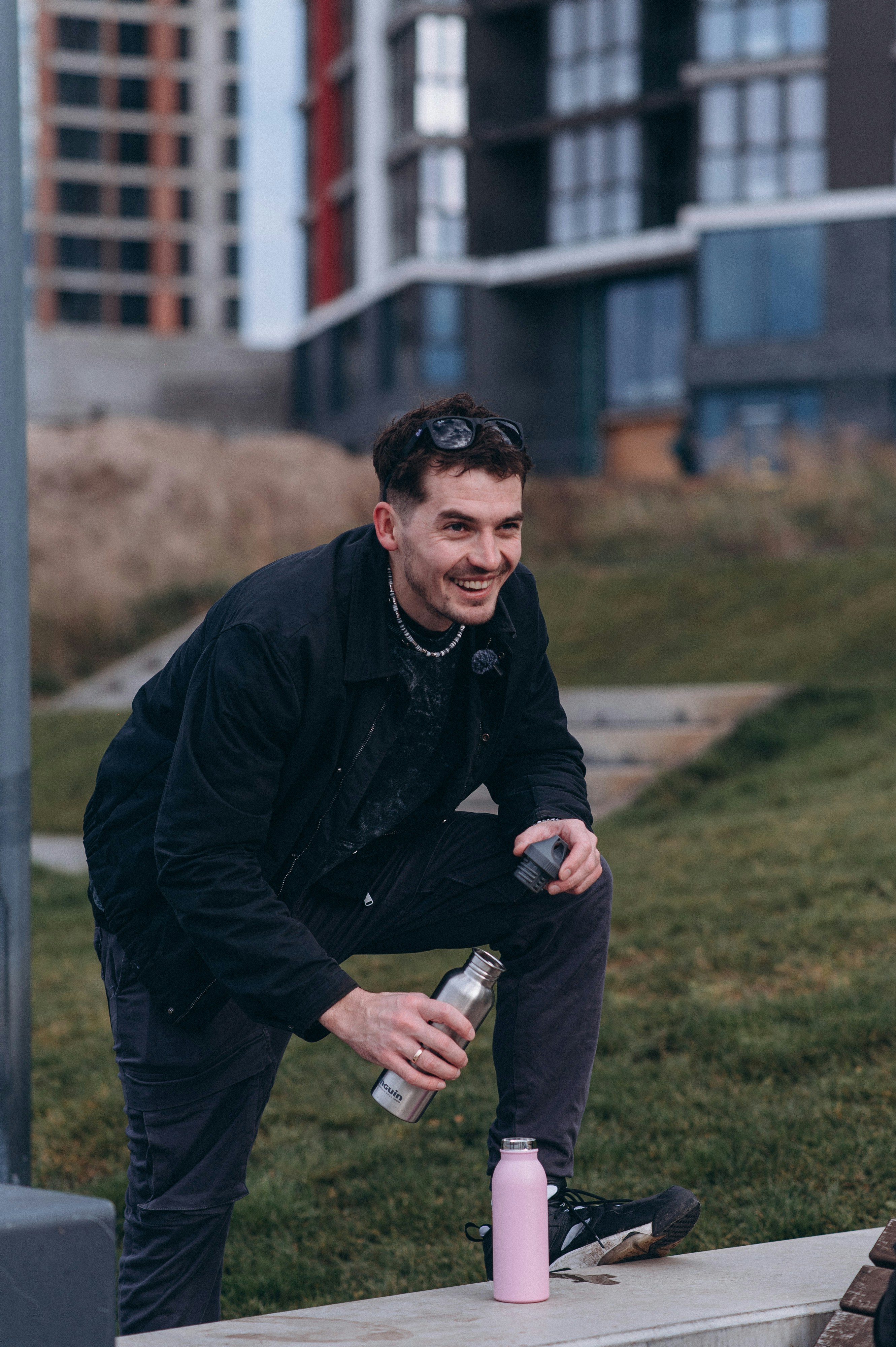 Lively moment on the park ledge: man with bottles and smile