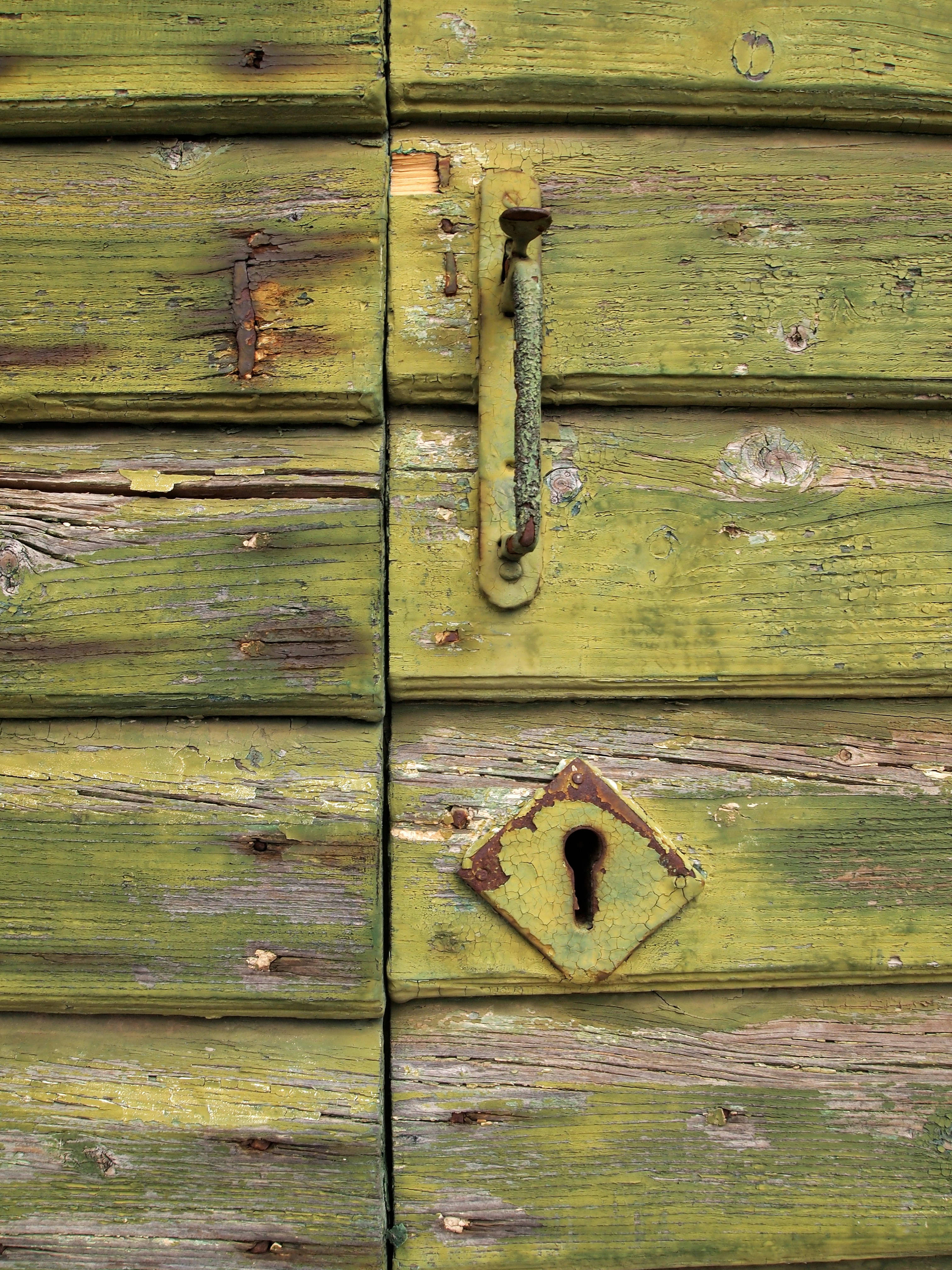 Weathered Green Door: Rusted Handle and Keyhole Tell-Tale History