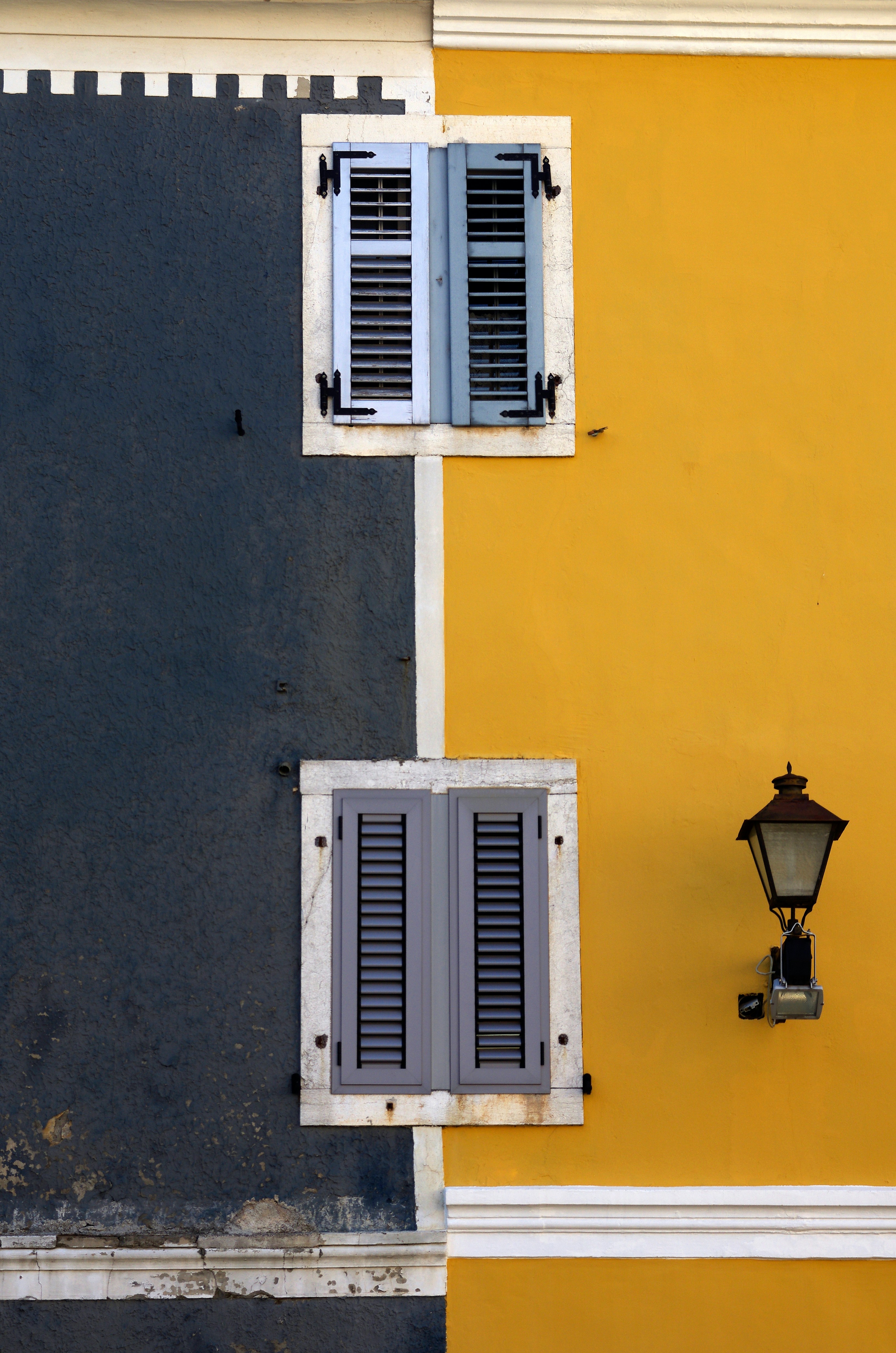 Two-Tone Facade: A Windowed Quiet Between Blue and Gold