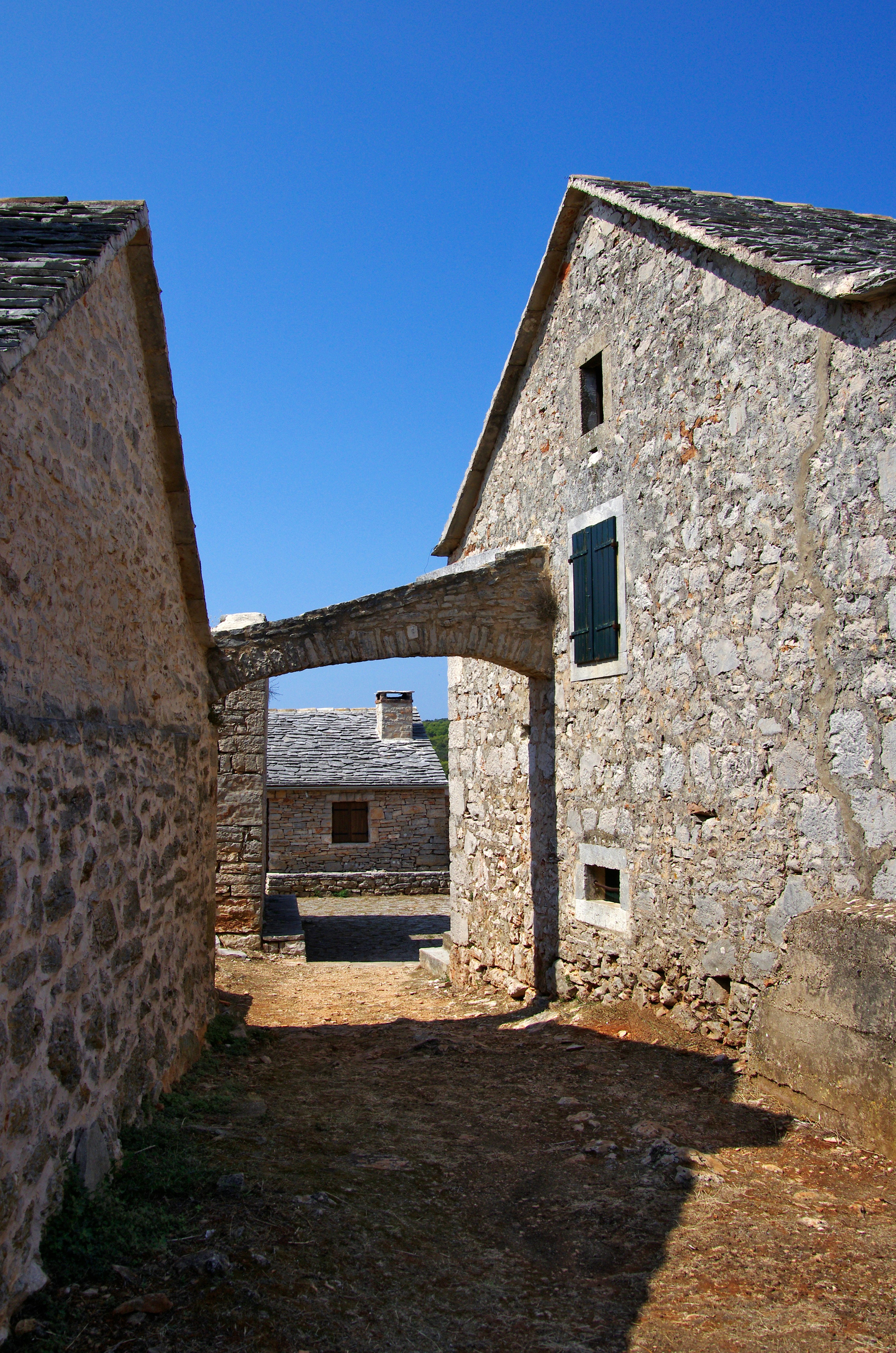 Archway Between Stone Houses: A Sunlit Pathway Through Time