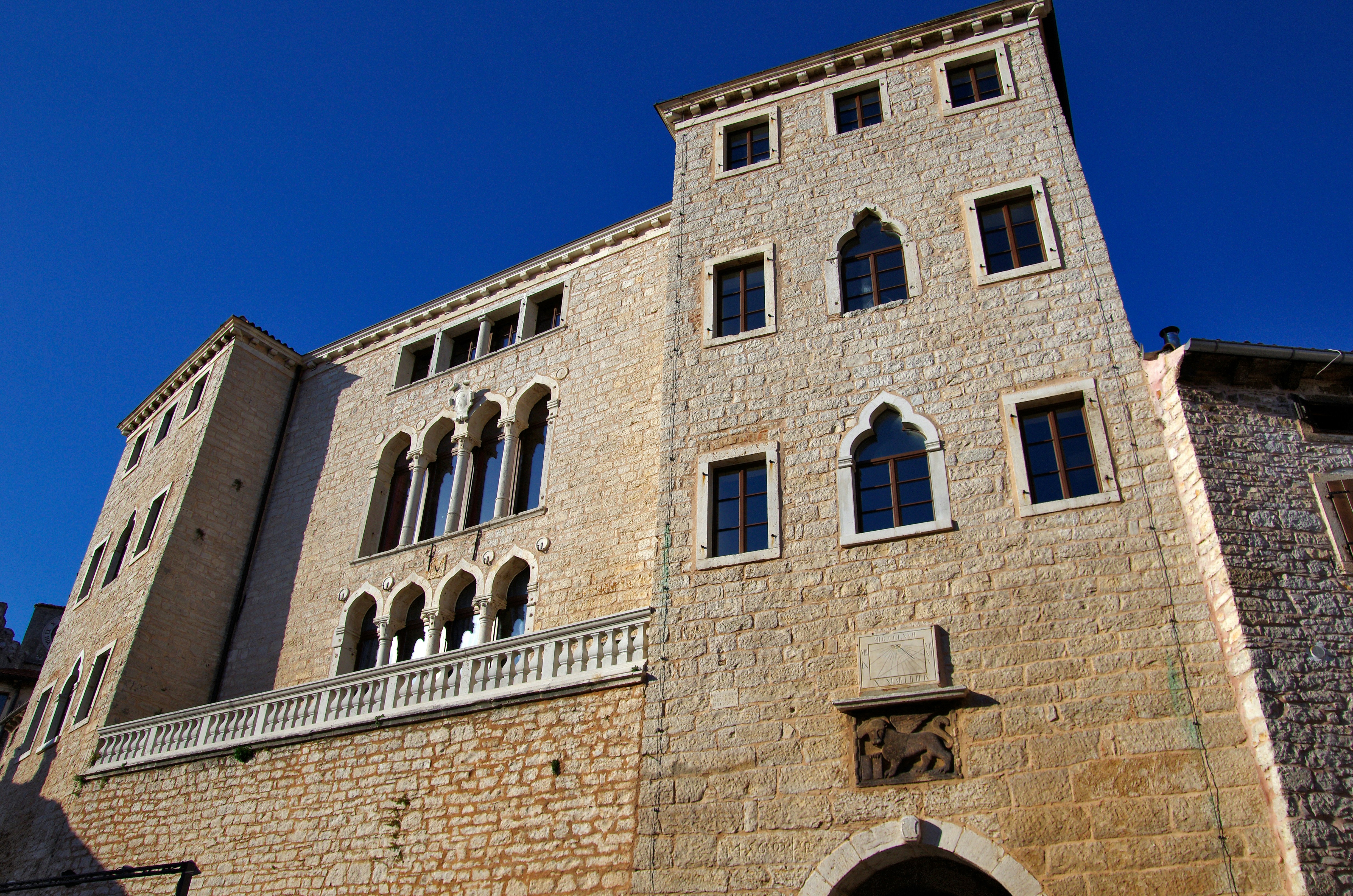 Stone Facade in Clear Blue: A Medieval-Influenced College Building