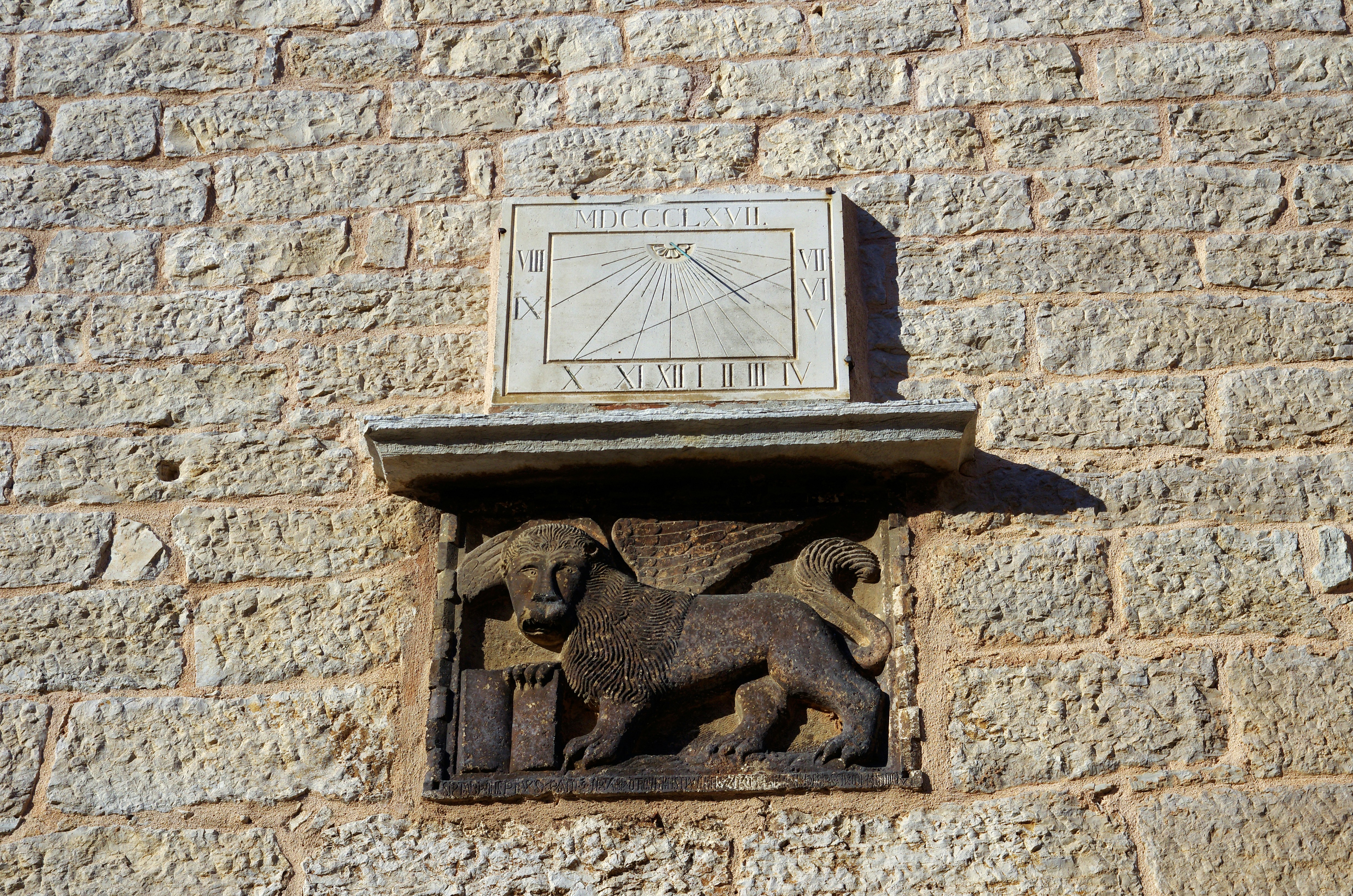 Sunlit Sundial Over a Stone Carved Lintel