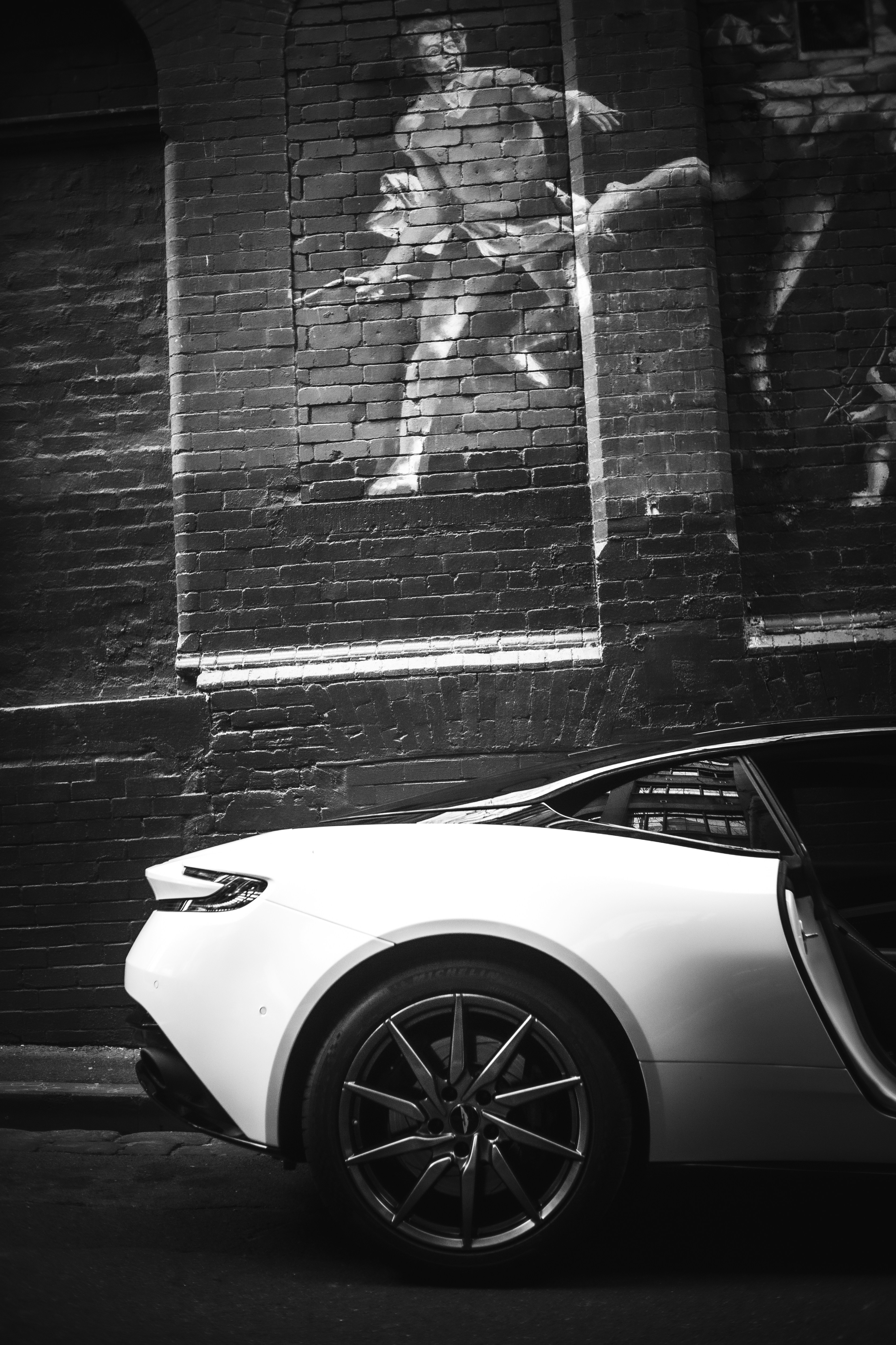 Chrome Moonlight: A Reclined Portrait of Speed Against Brick and Asphalt
