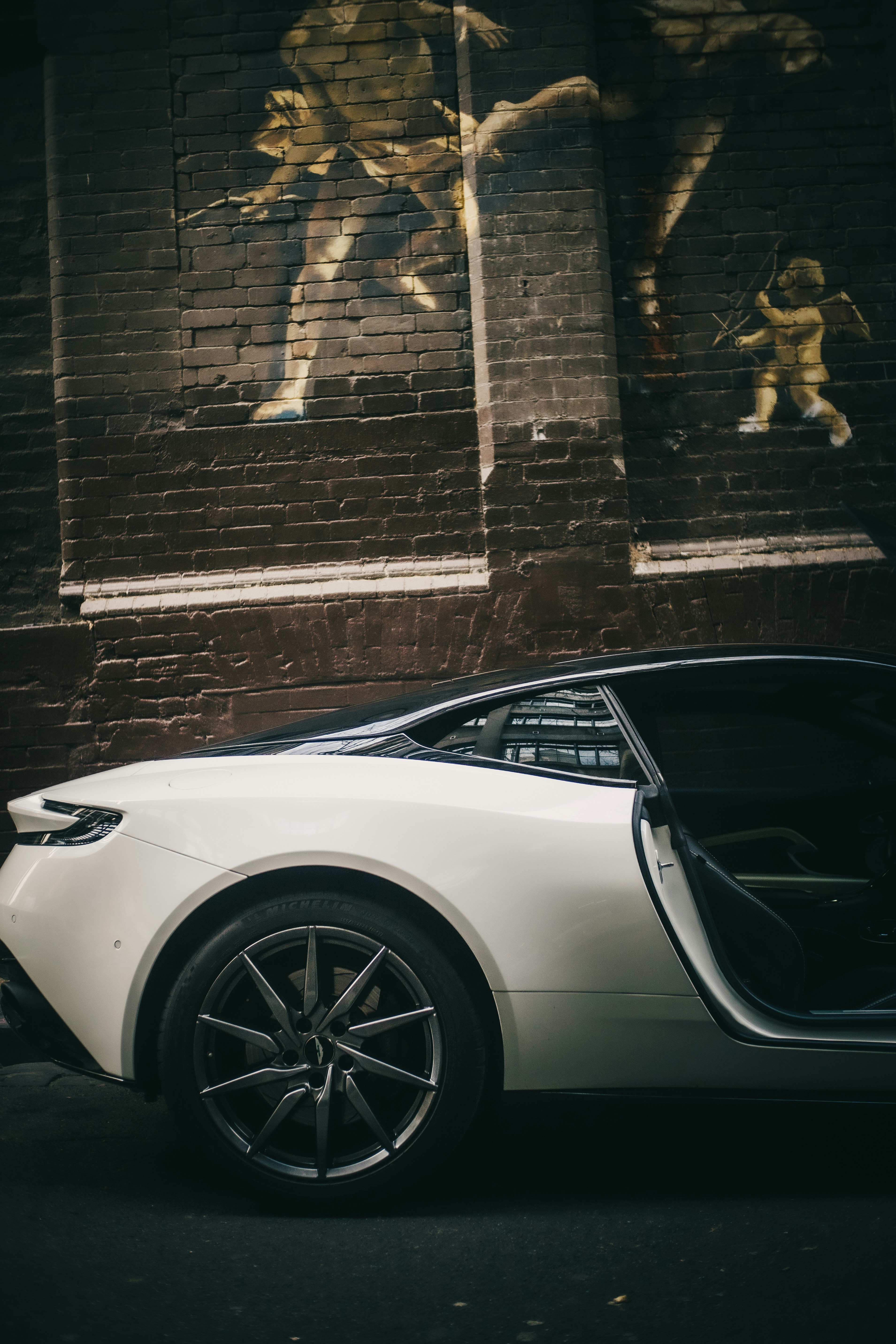 Chrome Glimmer: A Silver Sports Car Paused by a Graffiti Wall