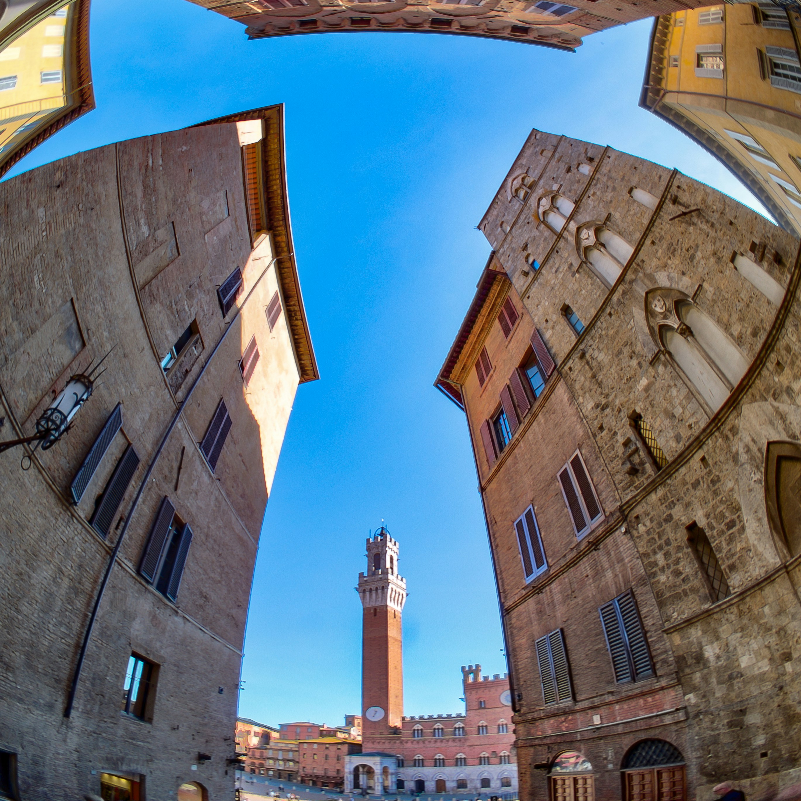 Vertical Spire of Piazza del Campo Framed by Narrow Tuscan Facades