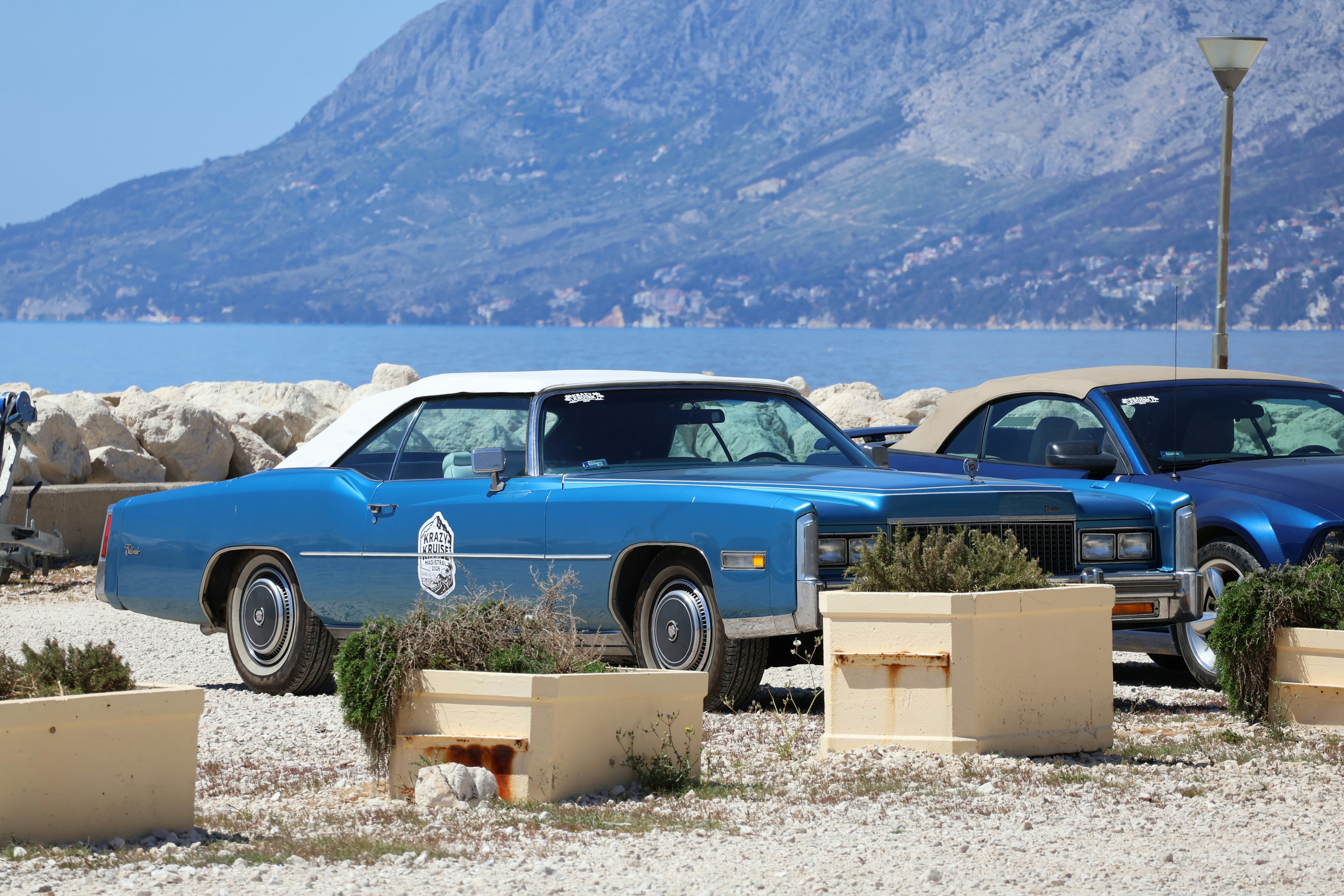 Blue Classic on a Pebble Lot with Sea and mountains