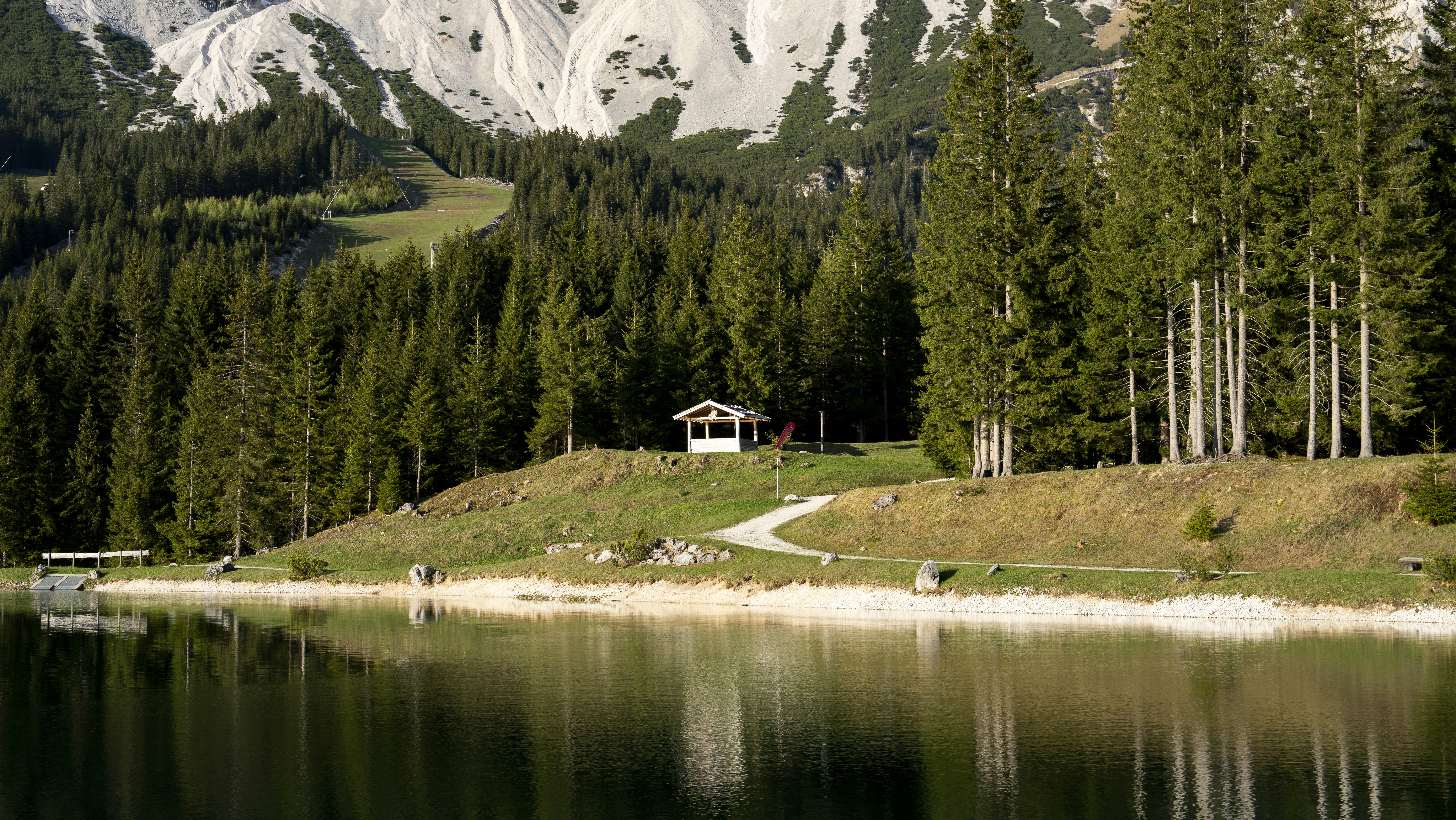 Lakeside Cabin Framed by Pines Under Alpine Snow