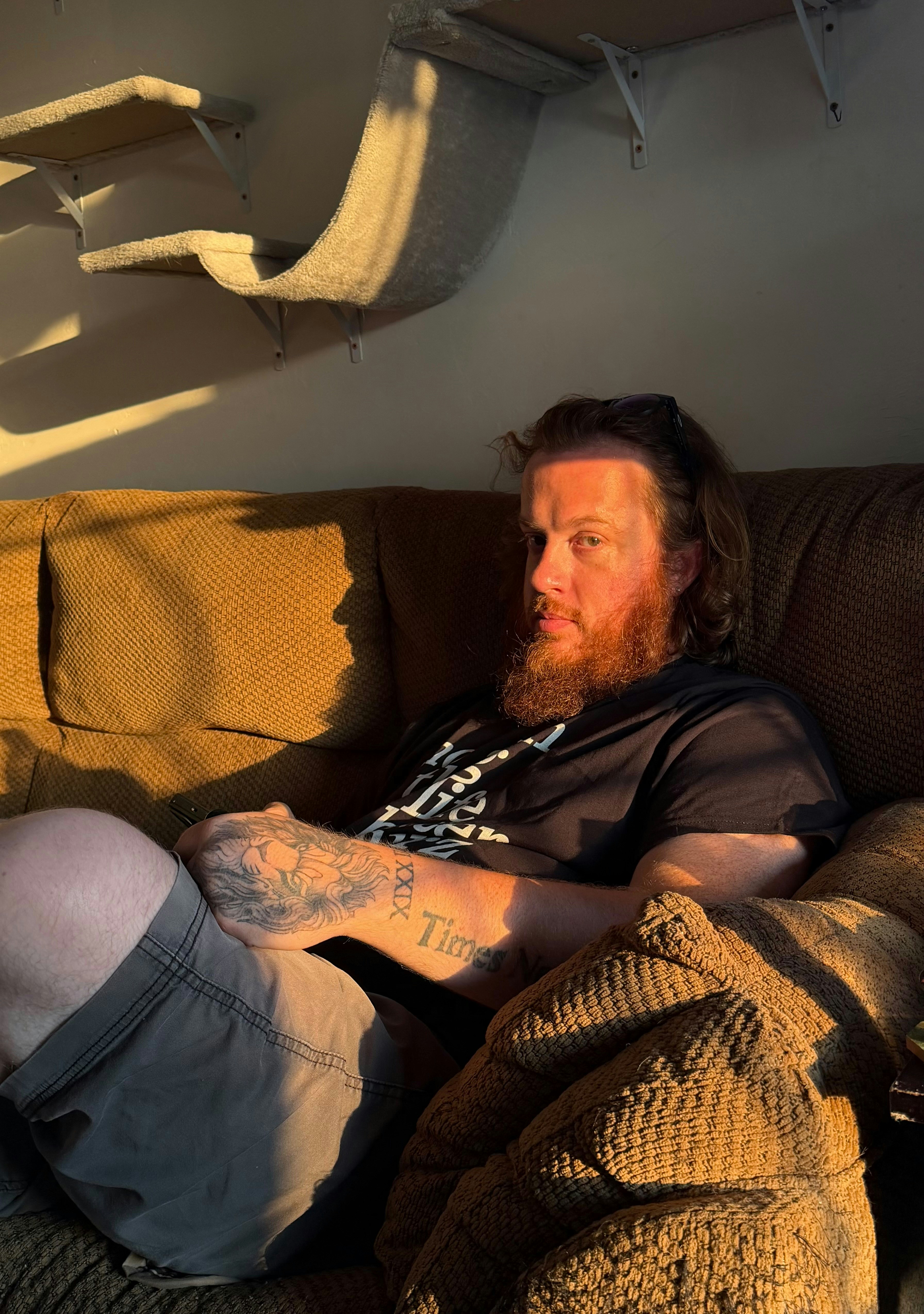 Golden Hour recline: a bearded man sinks into sunlit cushions