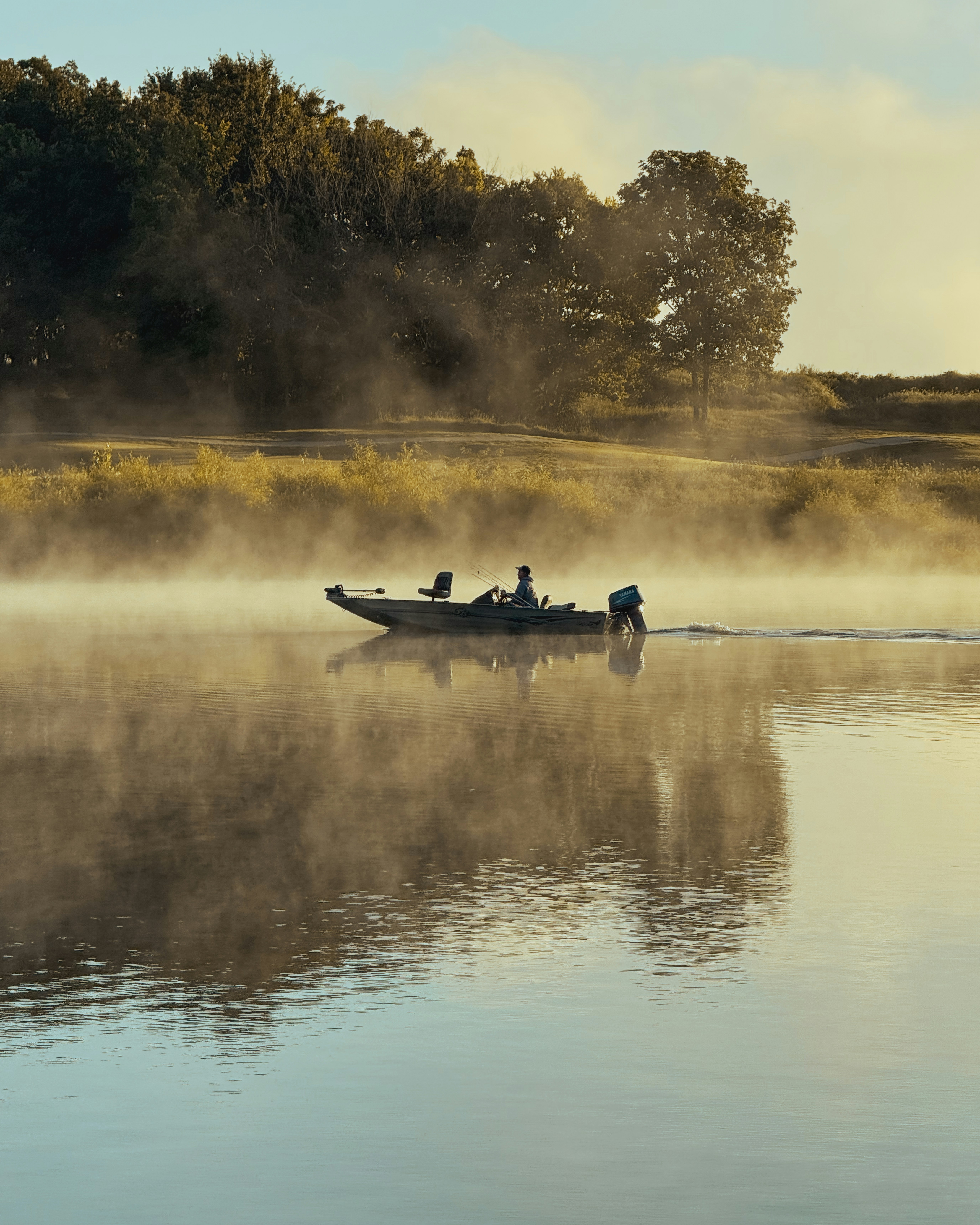 Misty River Passage: A Lone Boat in Calm Dawn