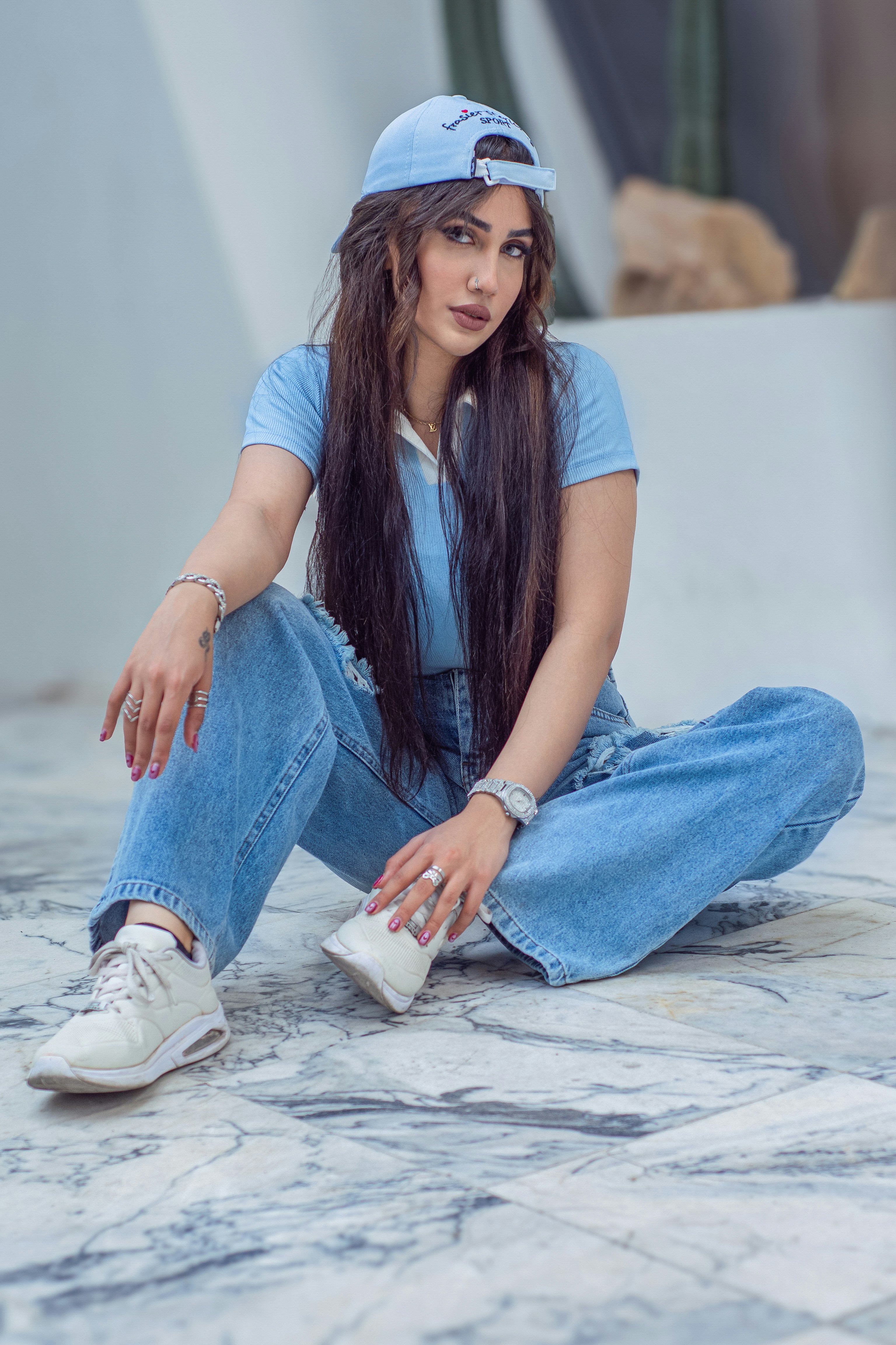 Blue-note Portrait: Young Woman in Casual Streetwear Seated on Marble Steps