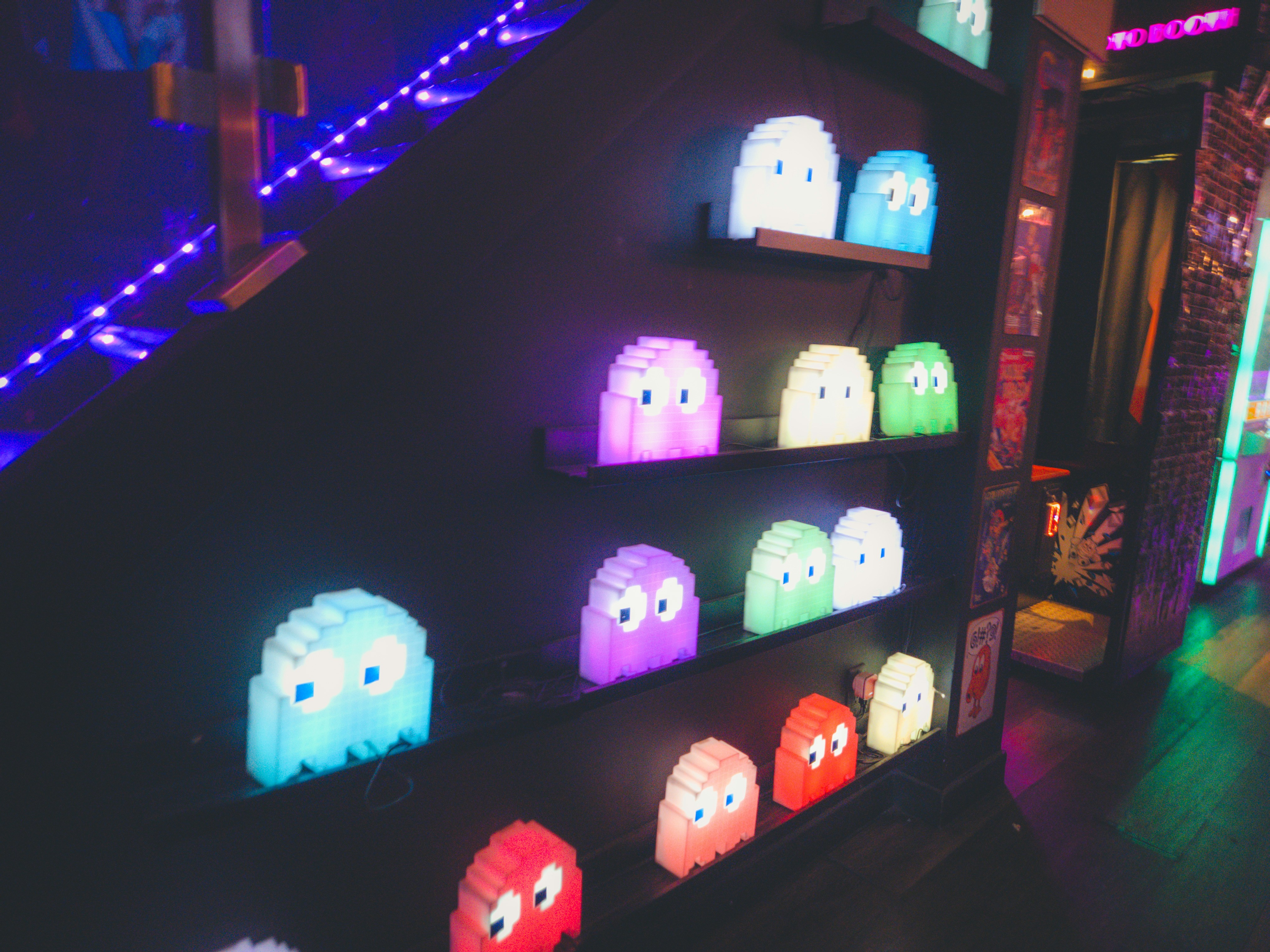 Neon Ghost Gallery: Multicolored Lit Faces on a Dark Staircase