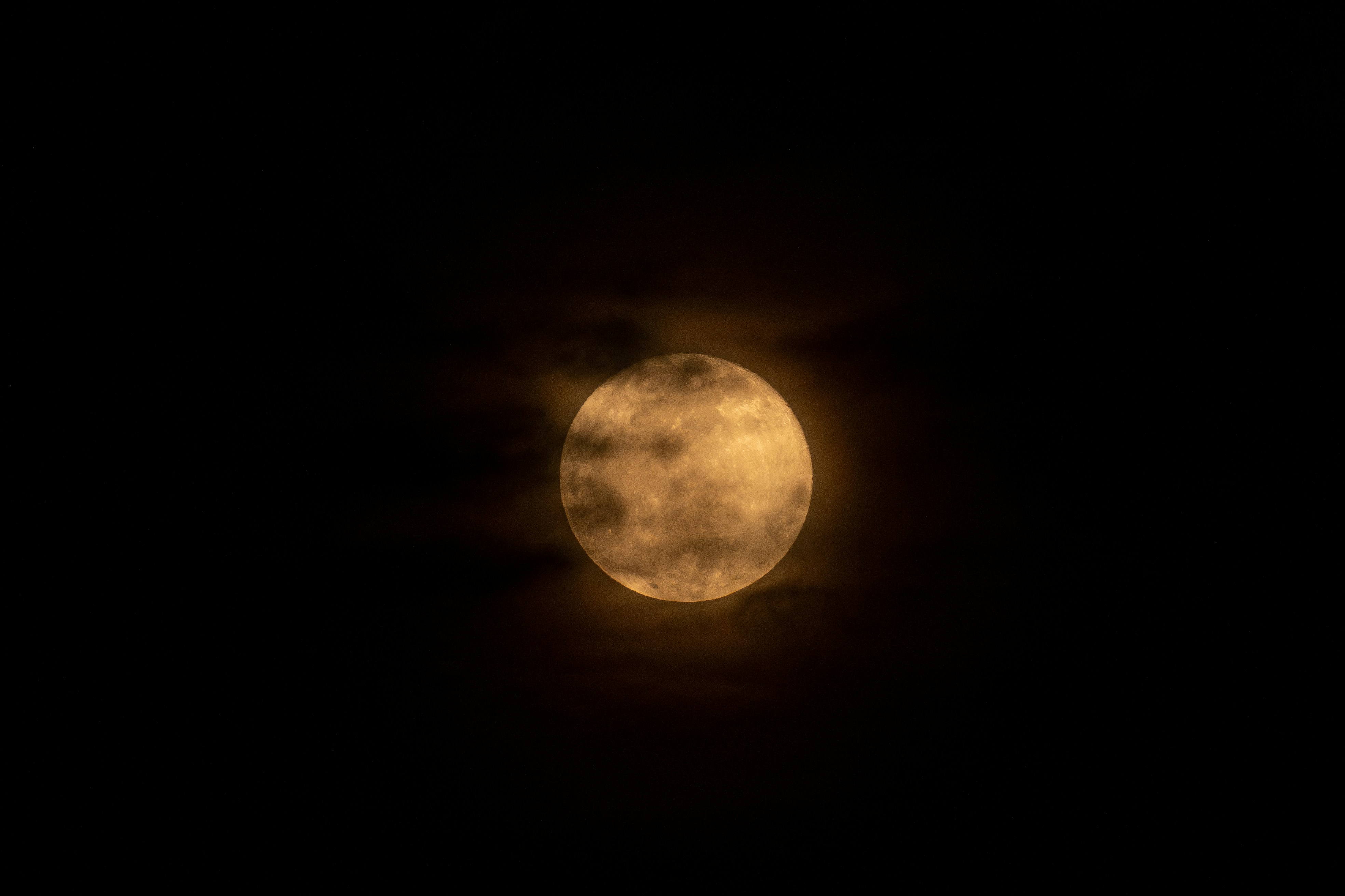 Lunar Glow Through Thin Veil: Moon Emerges from Night Clouds