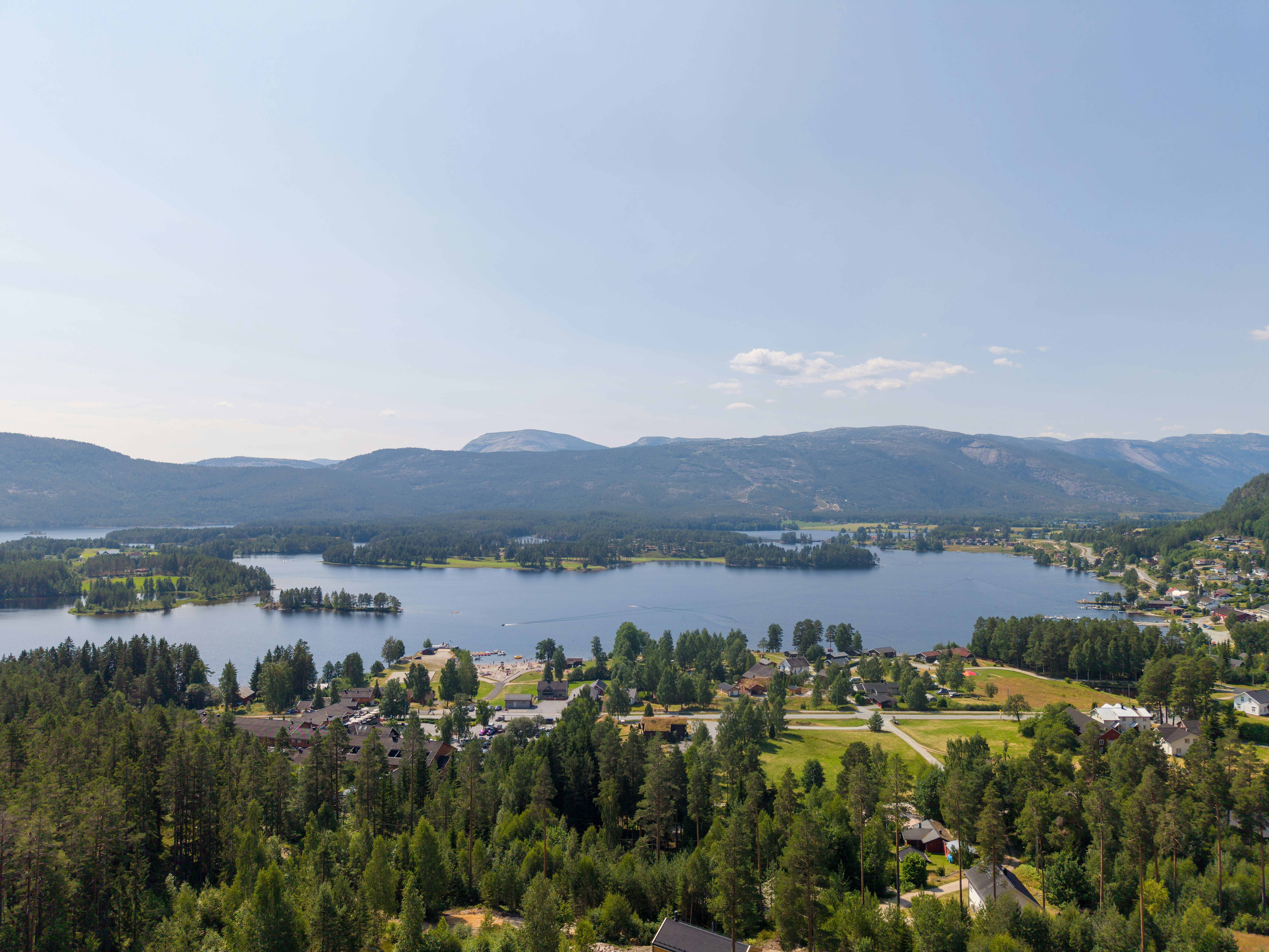 Sunlit lake valley: a serene drift through pine and village