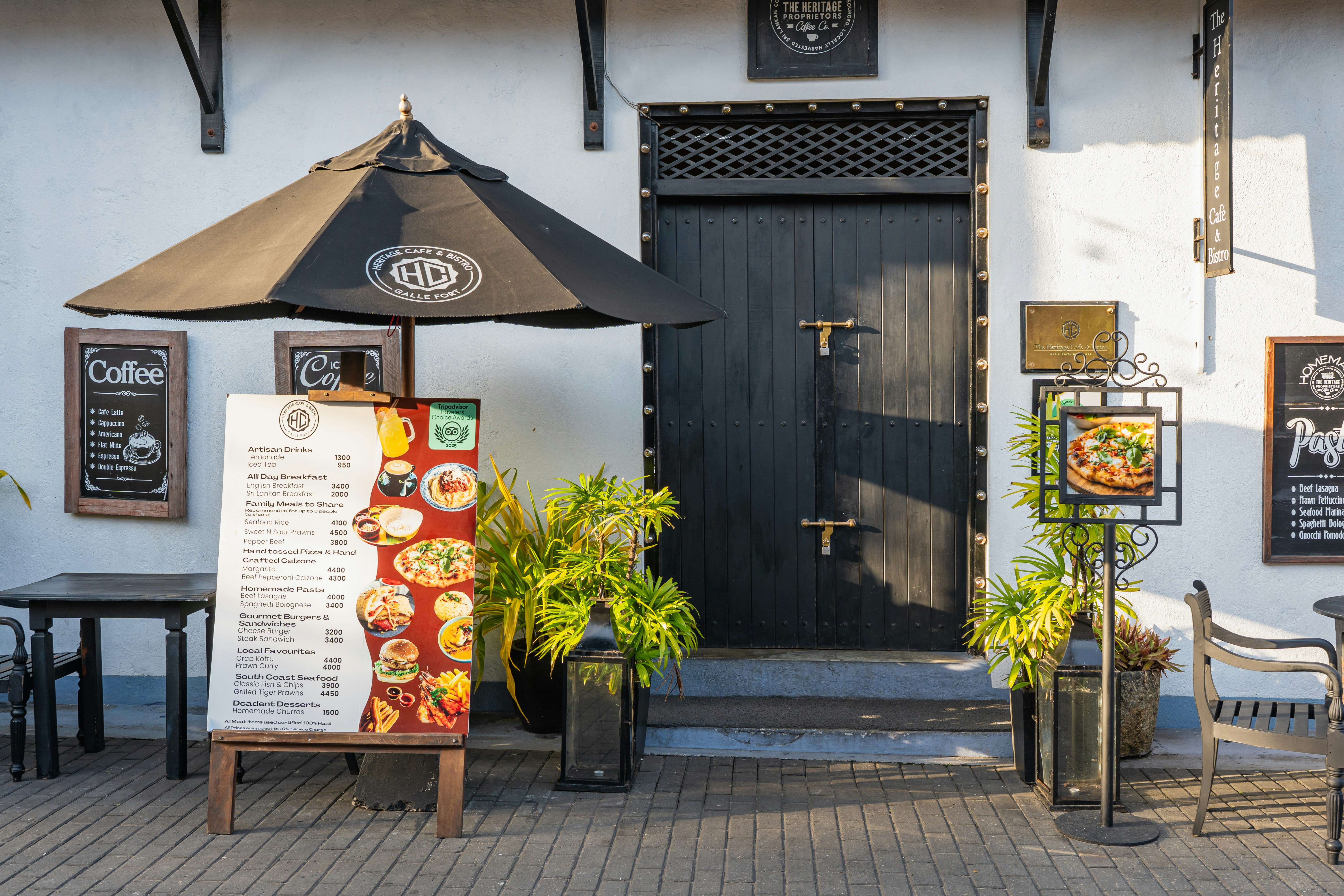 Cafe Exterior with Menu Board and Potted Plants Framing a Central Door