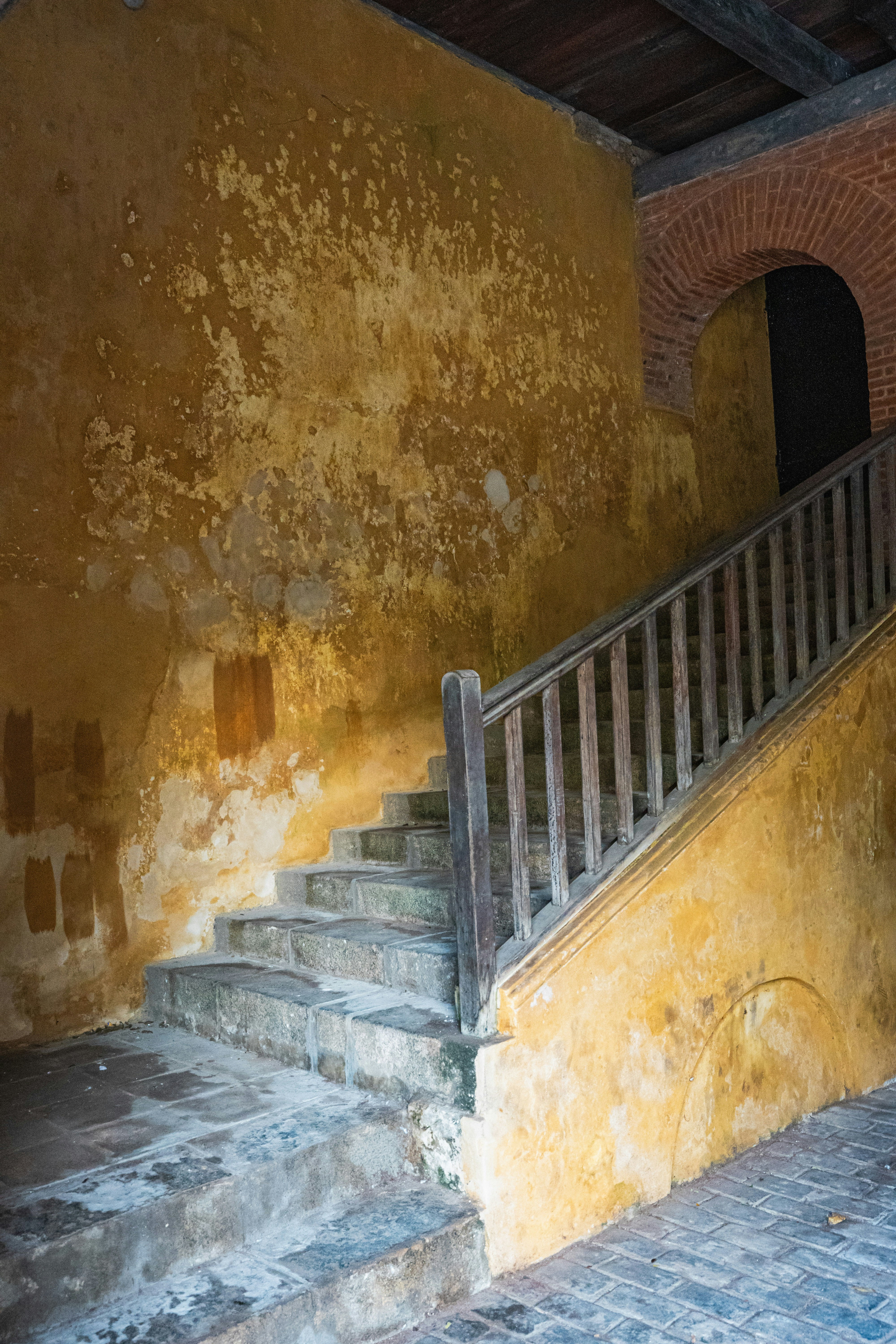 Sunlit Staircase Winding into an Old Stone Archway