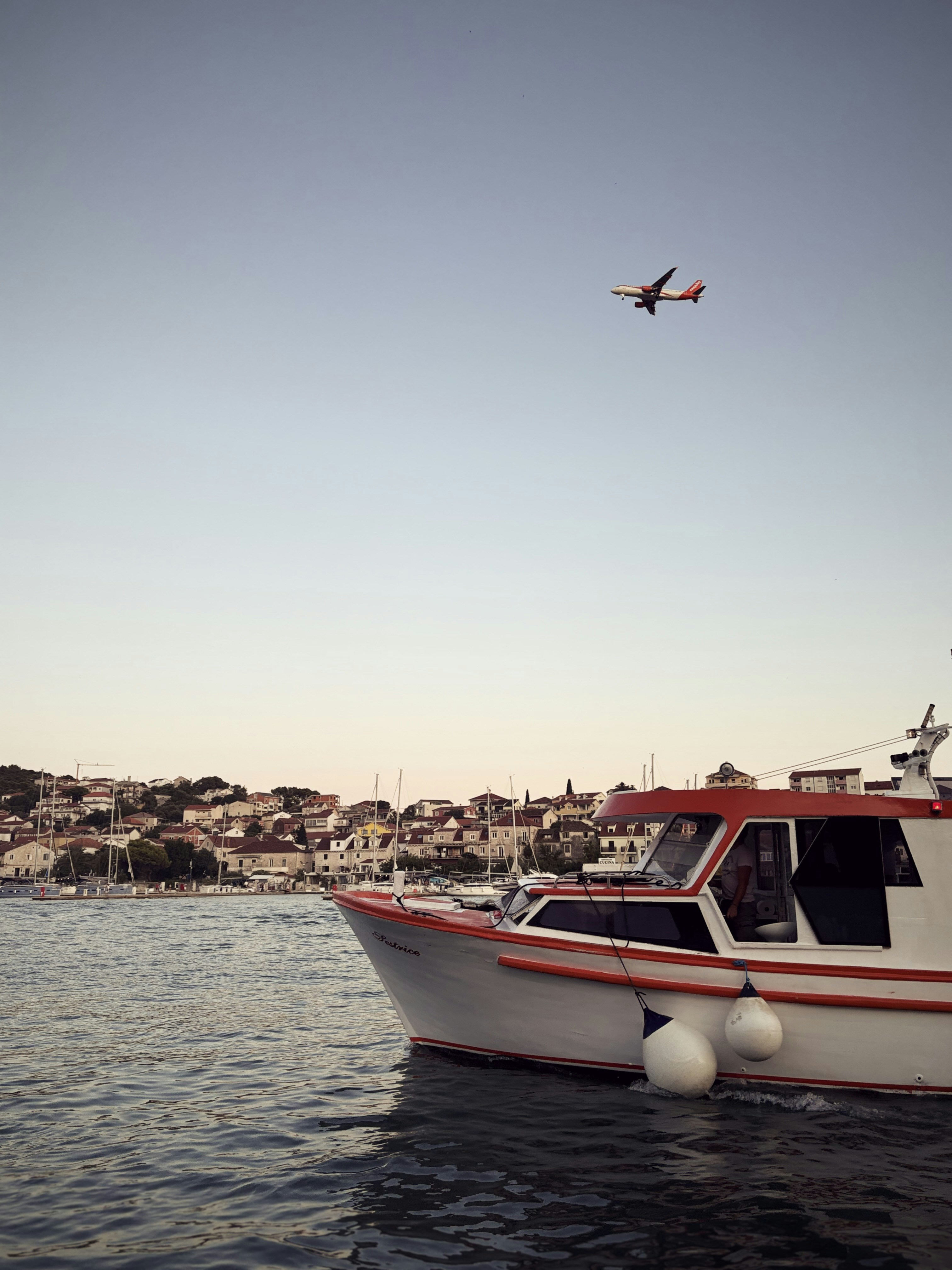 Harbor Silhouette: A Red-Trim Boat Meets a Distant Sky