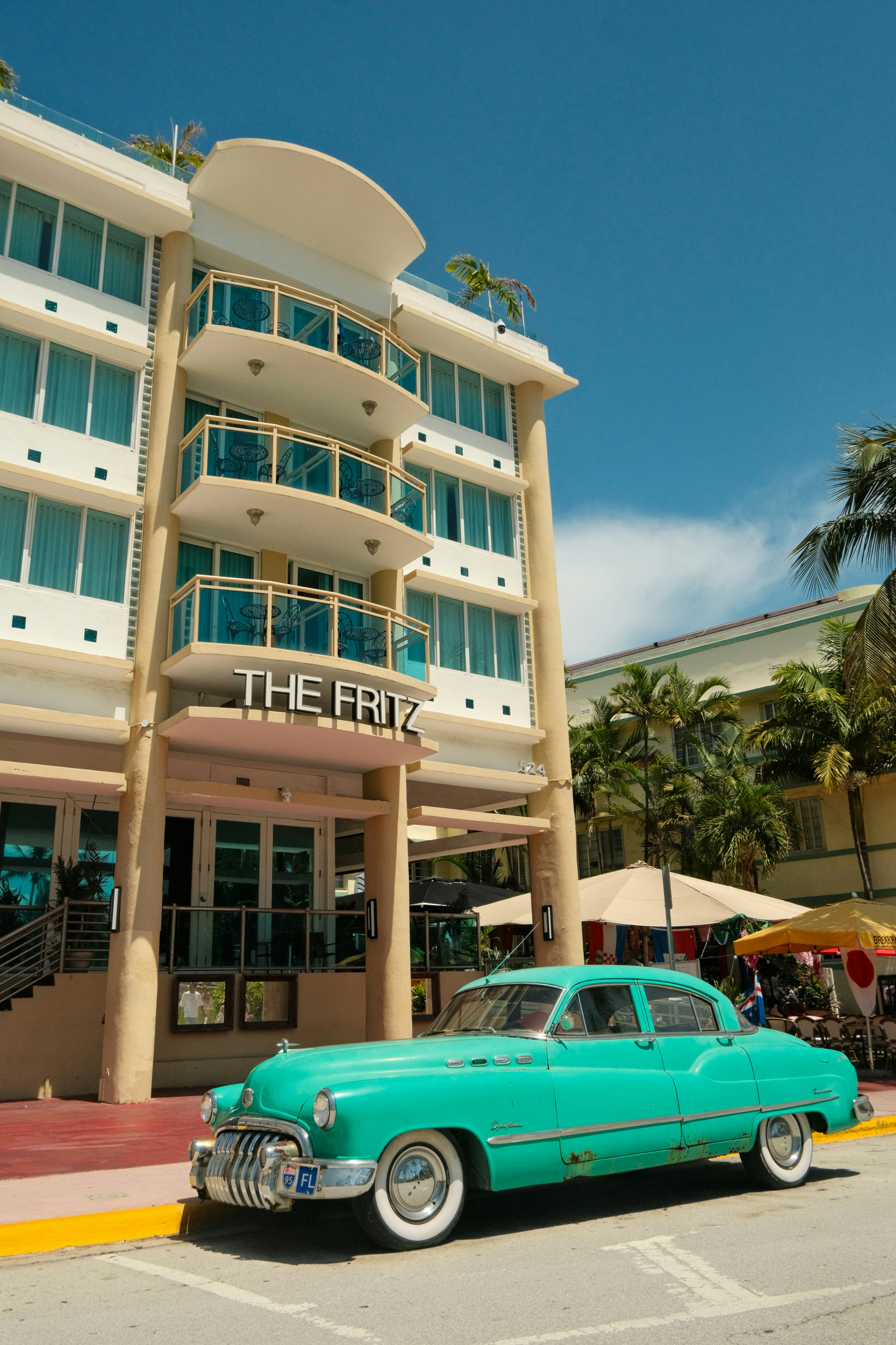 Retro Riviera: The Faded Turquoise Classic in Front of Art-Deco Hotel