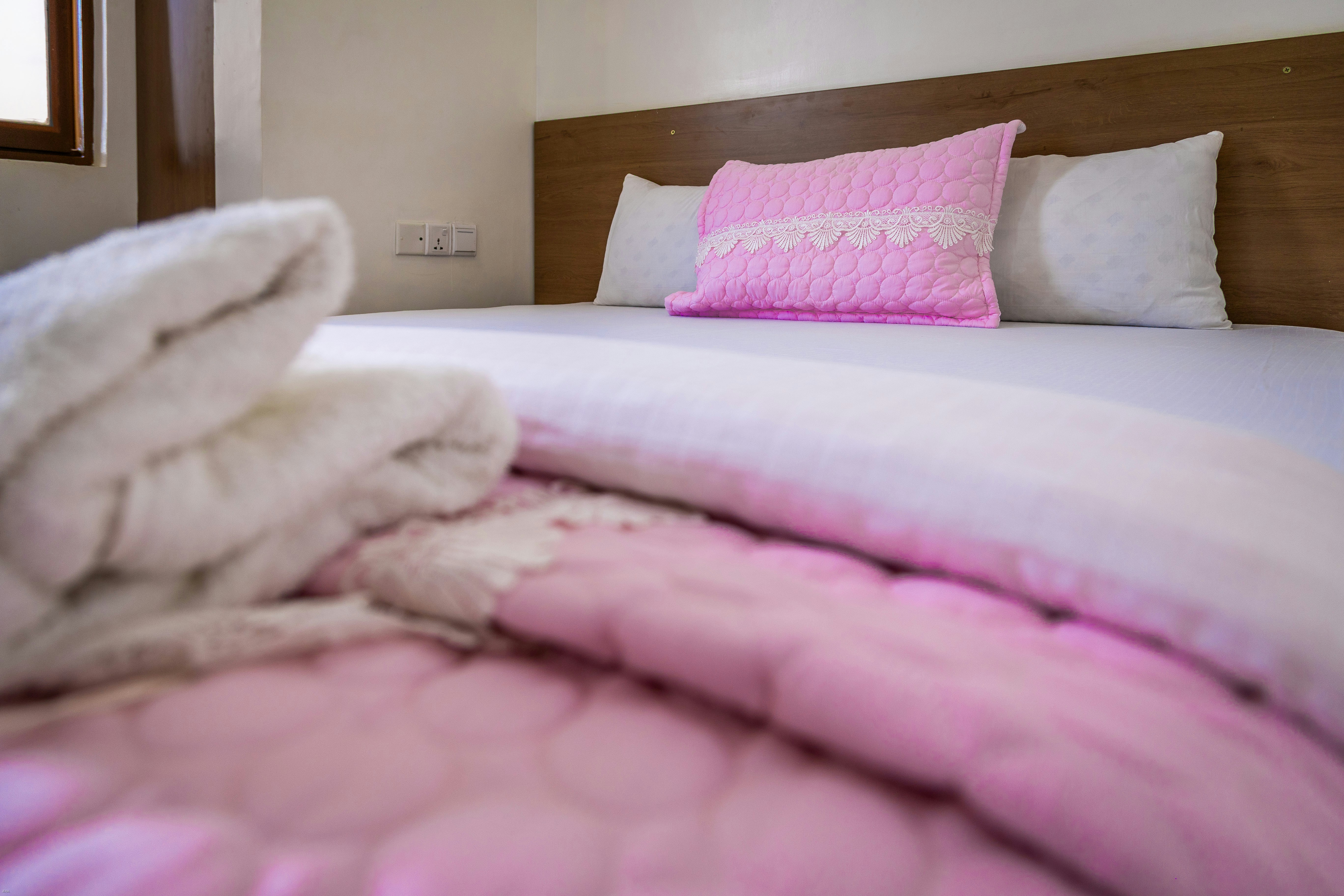 Pastel Comfort: A Cozy Bed With Layered Throws