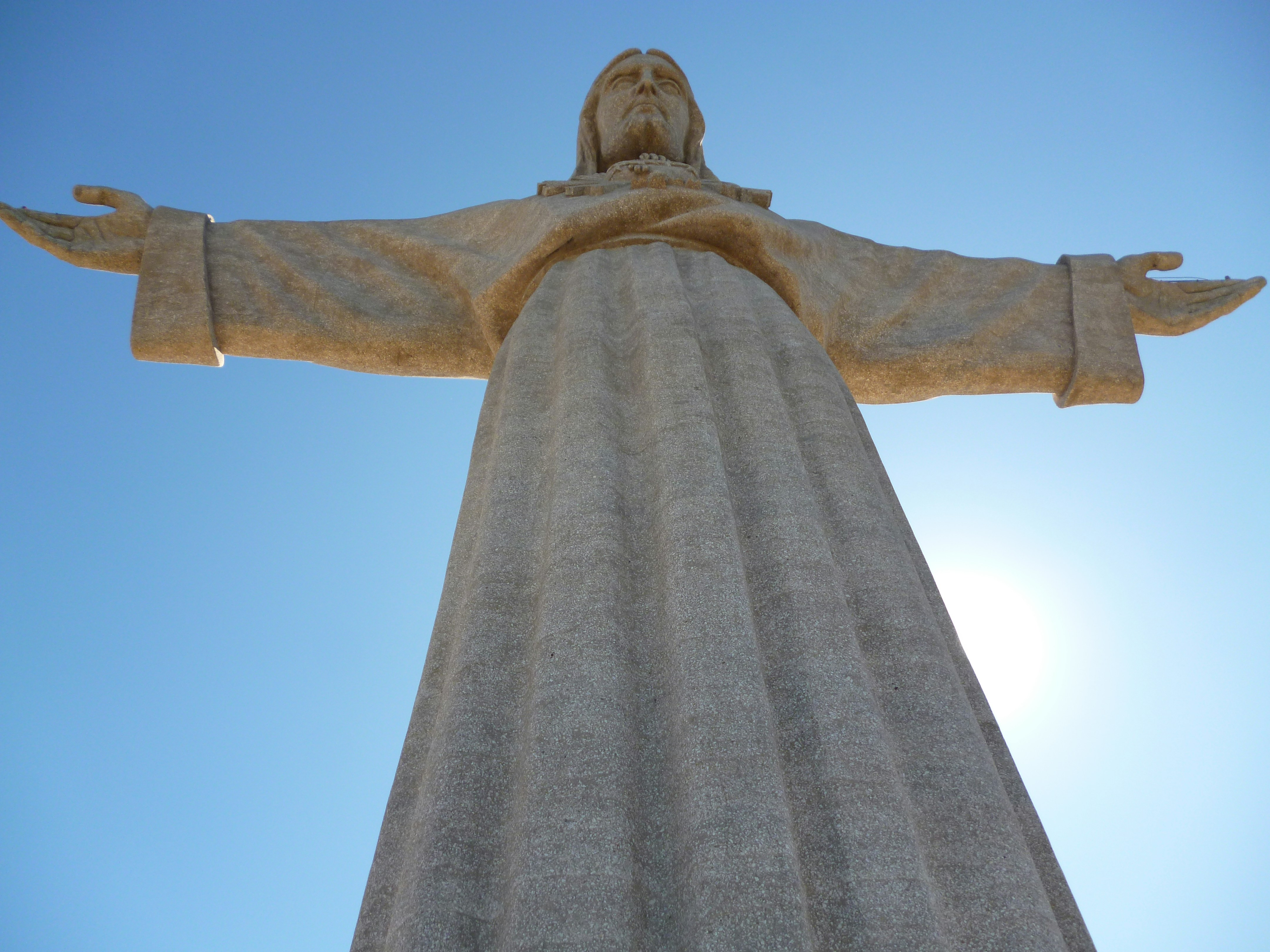Looming Silhouette: A Majestic Christlike Statue Reaching Toward the Sky