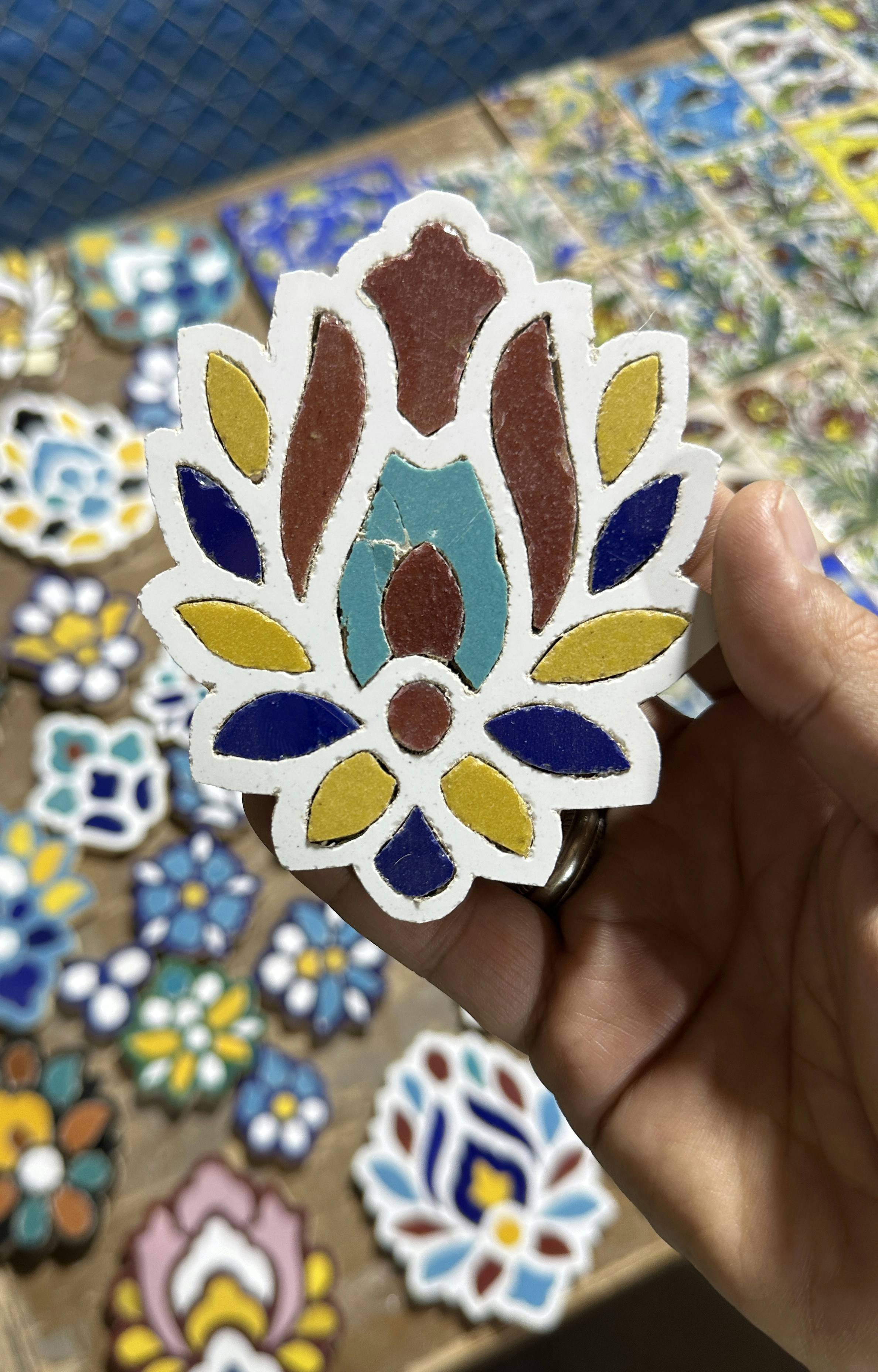 Colorful Floral Sticker Held Aloft Among Tiles