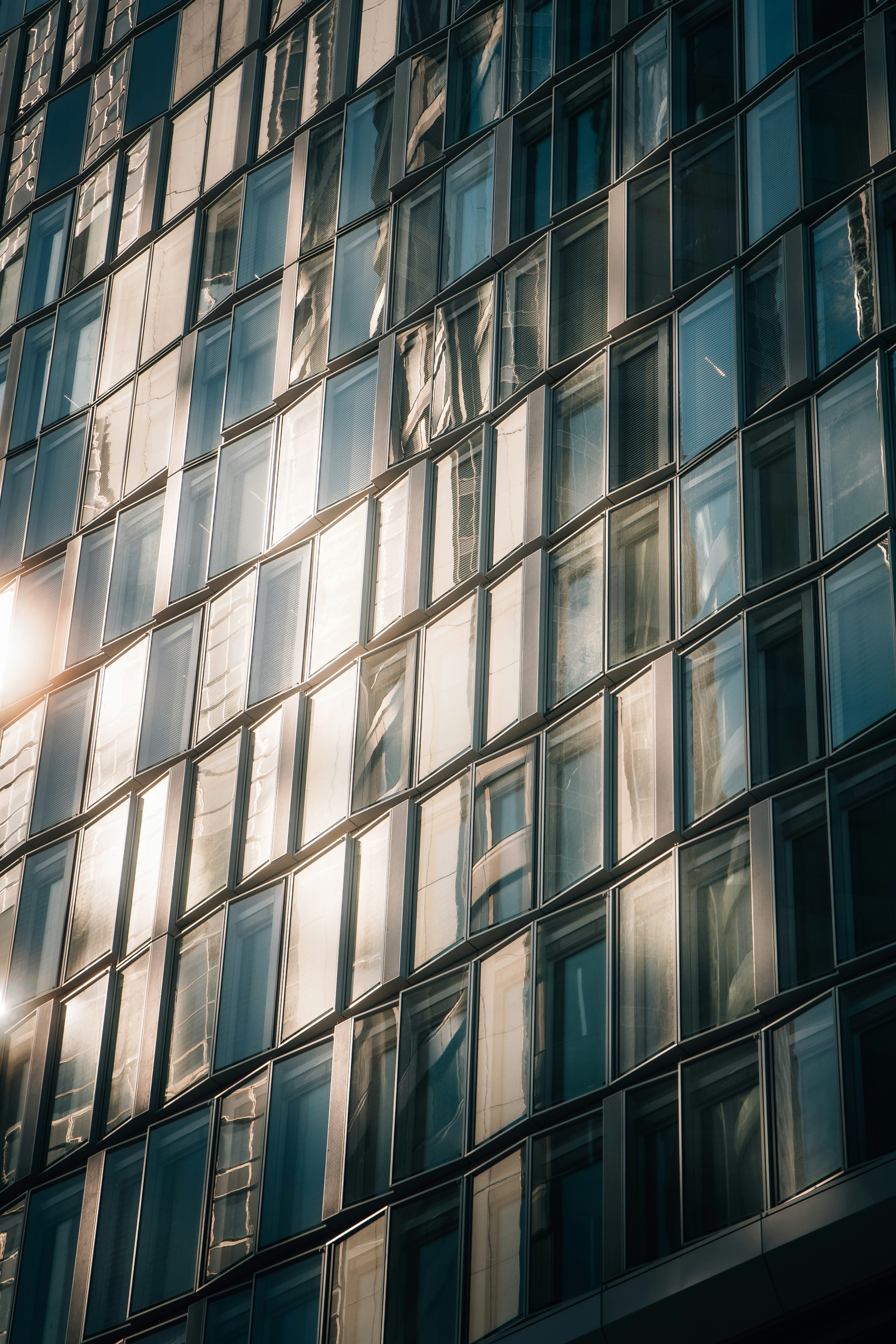 Glinting Facade: Sunlight Traces Through Glass Grids