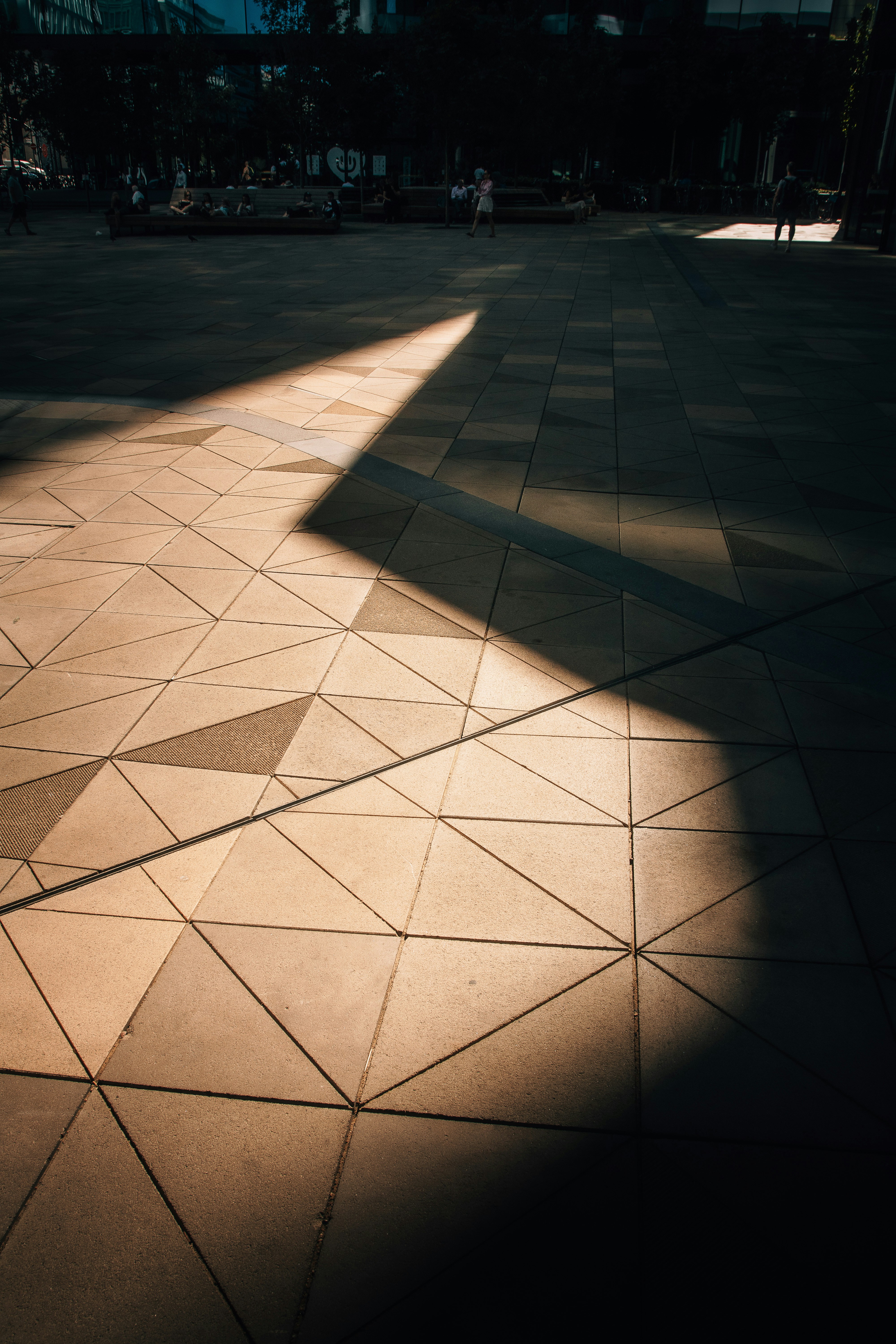 Shadowed Triangle: Sunlit Tiles Cutting Across a Quiet Plaza