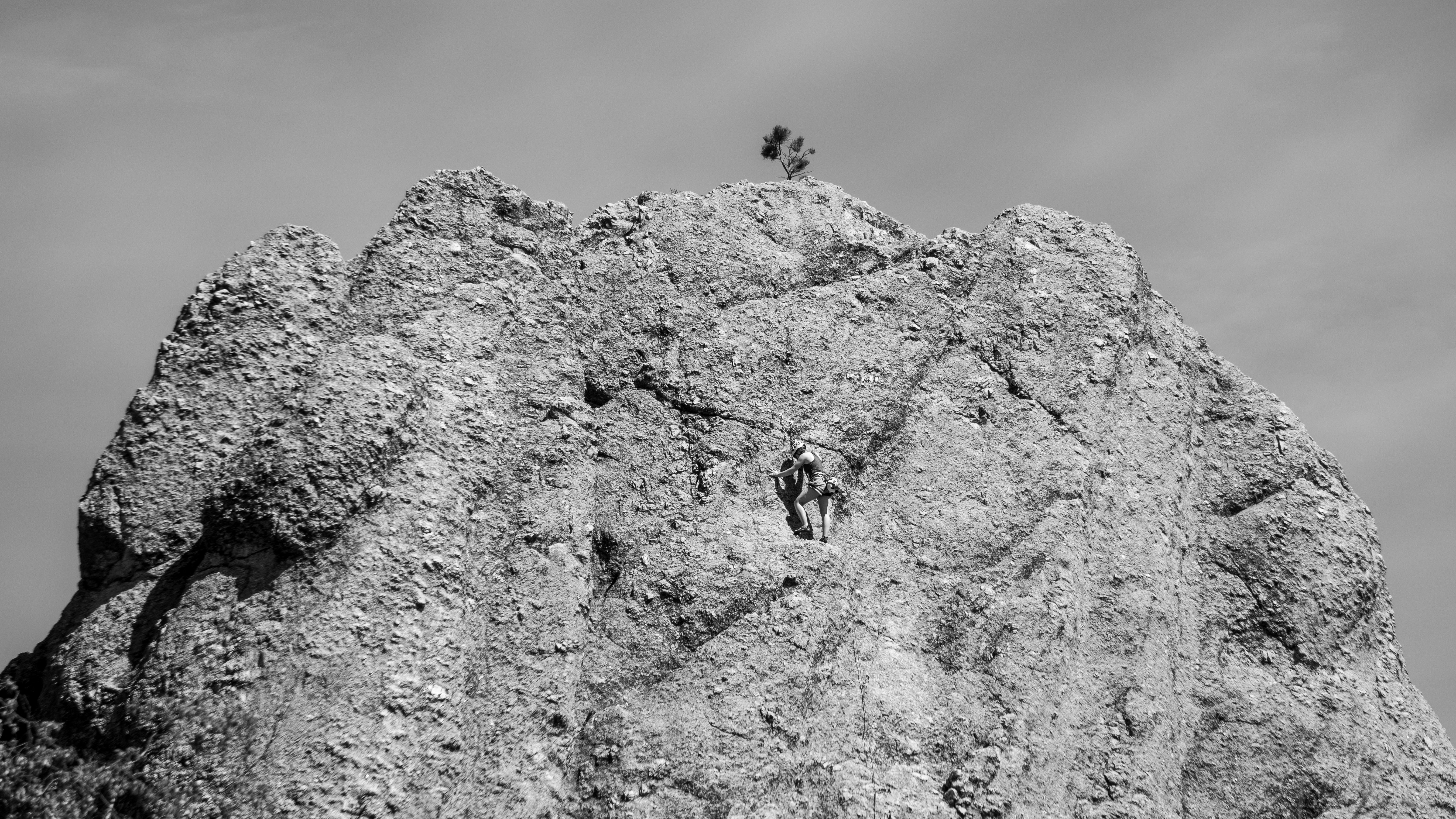 Rugged Peak Watcher: A Lone Figure Clinging to the Crag