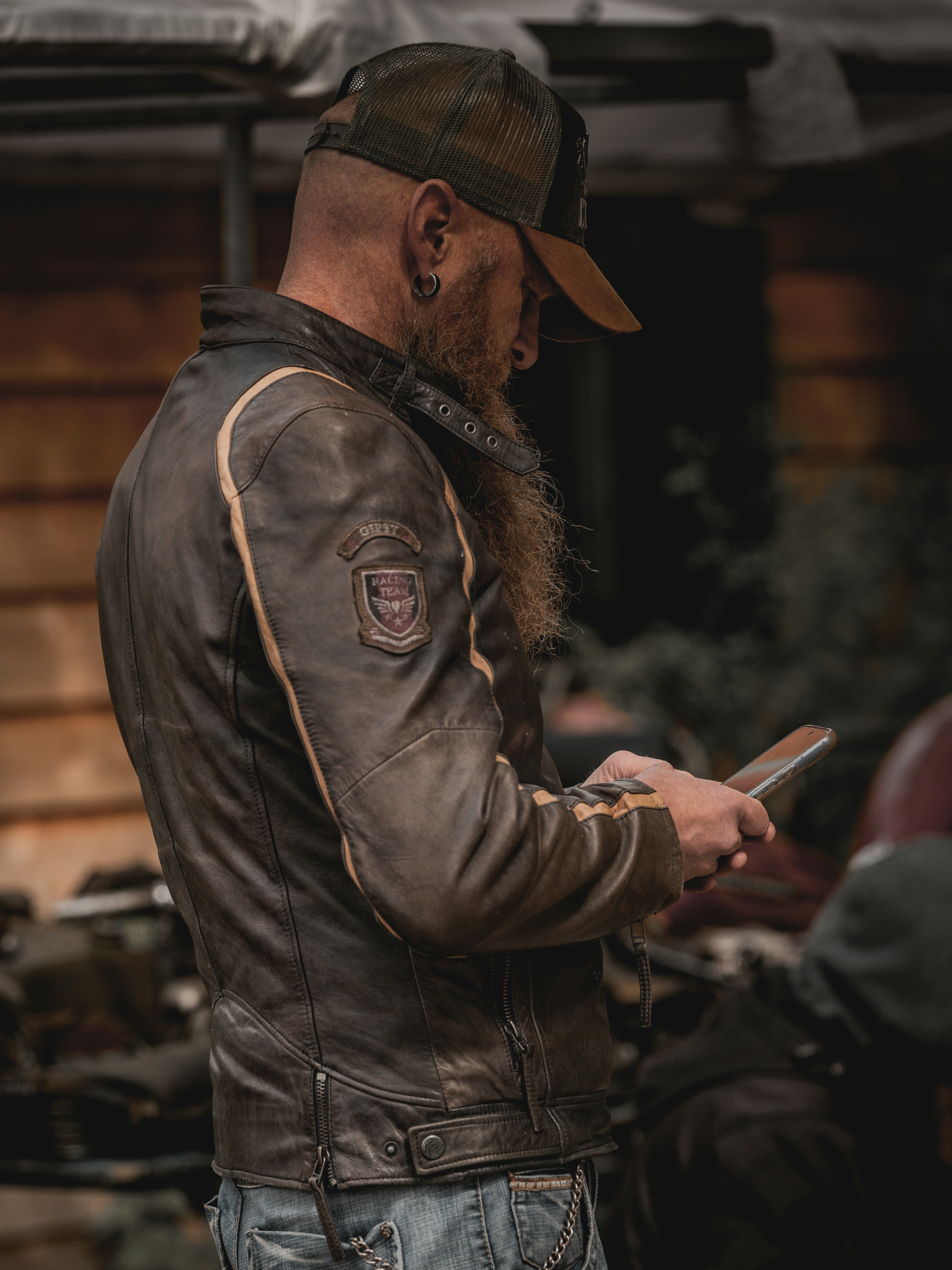 Leather and Screen: A Moment with a Bearded Rider Focused on a Tablet