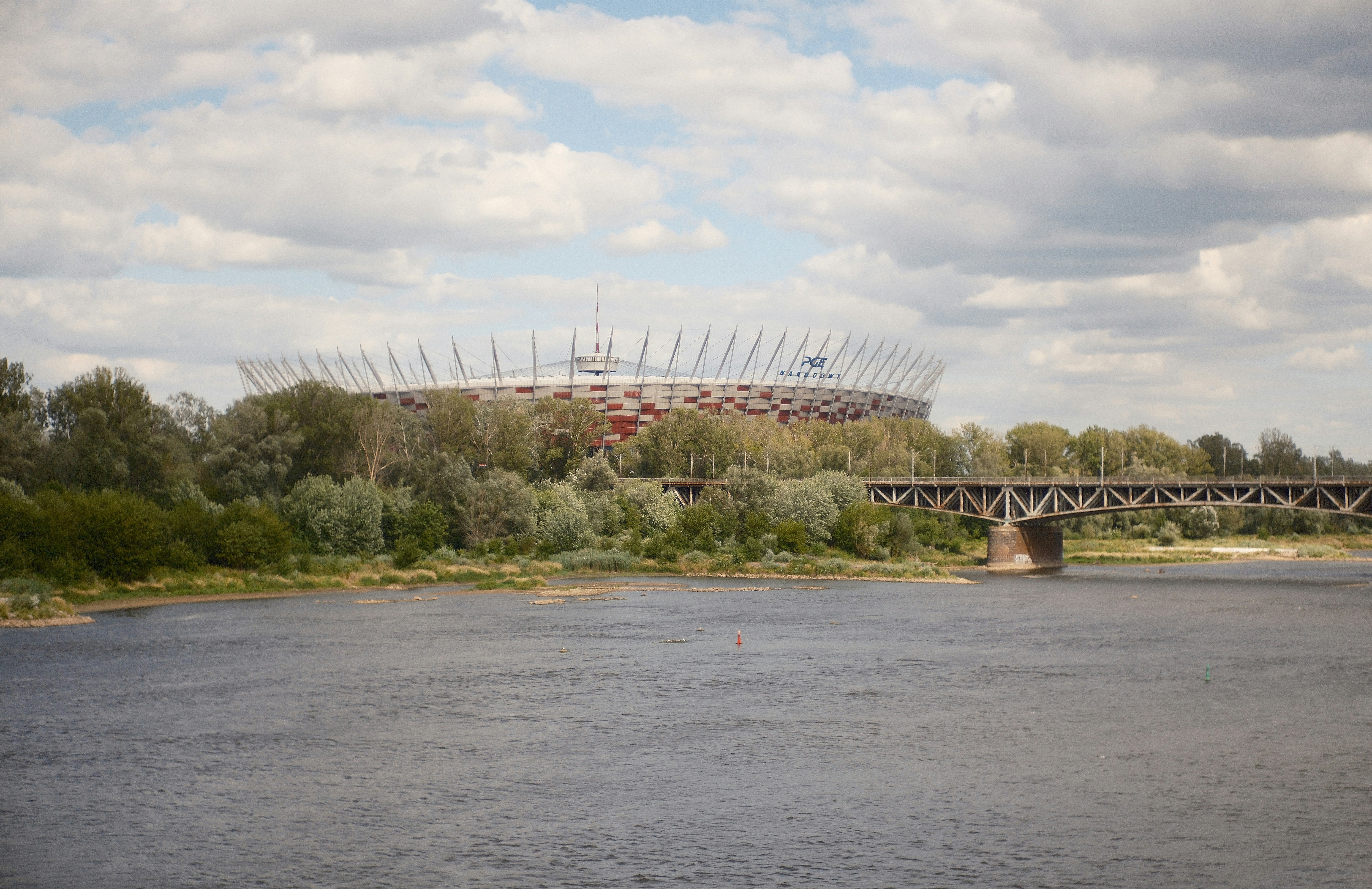 Overlooked Arc: Stadium Silhouette Above a Riverside Bend