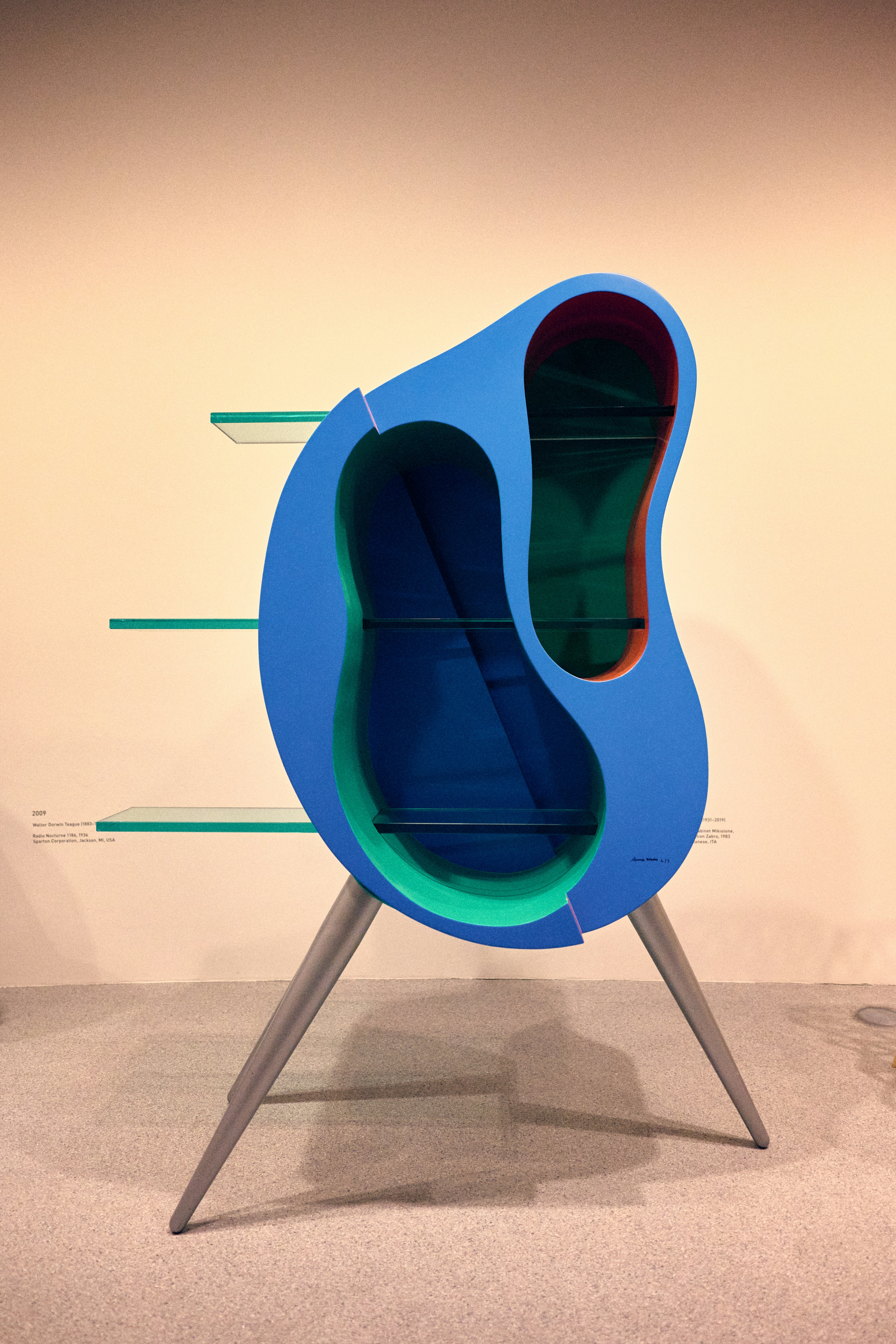 Blue Sculpted Cabinet on Tripod Legs in Gallery Light