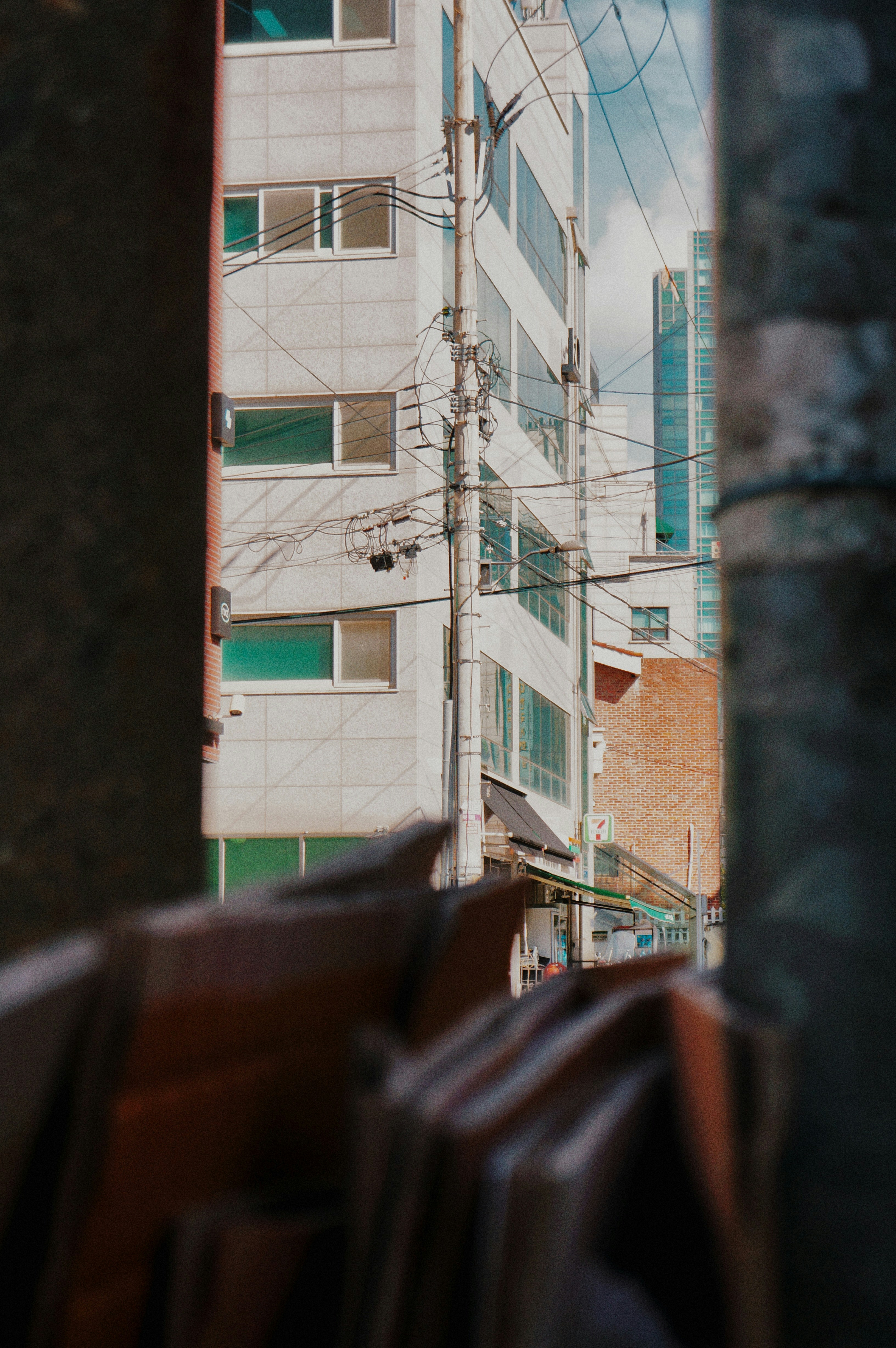 Narrow urban alleyway peering between tall glass-fronted buildings